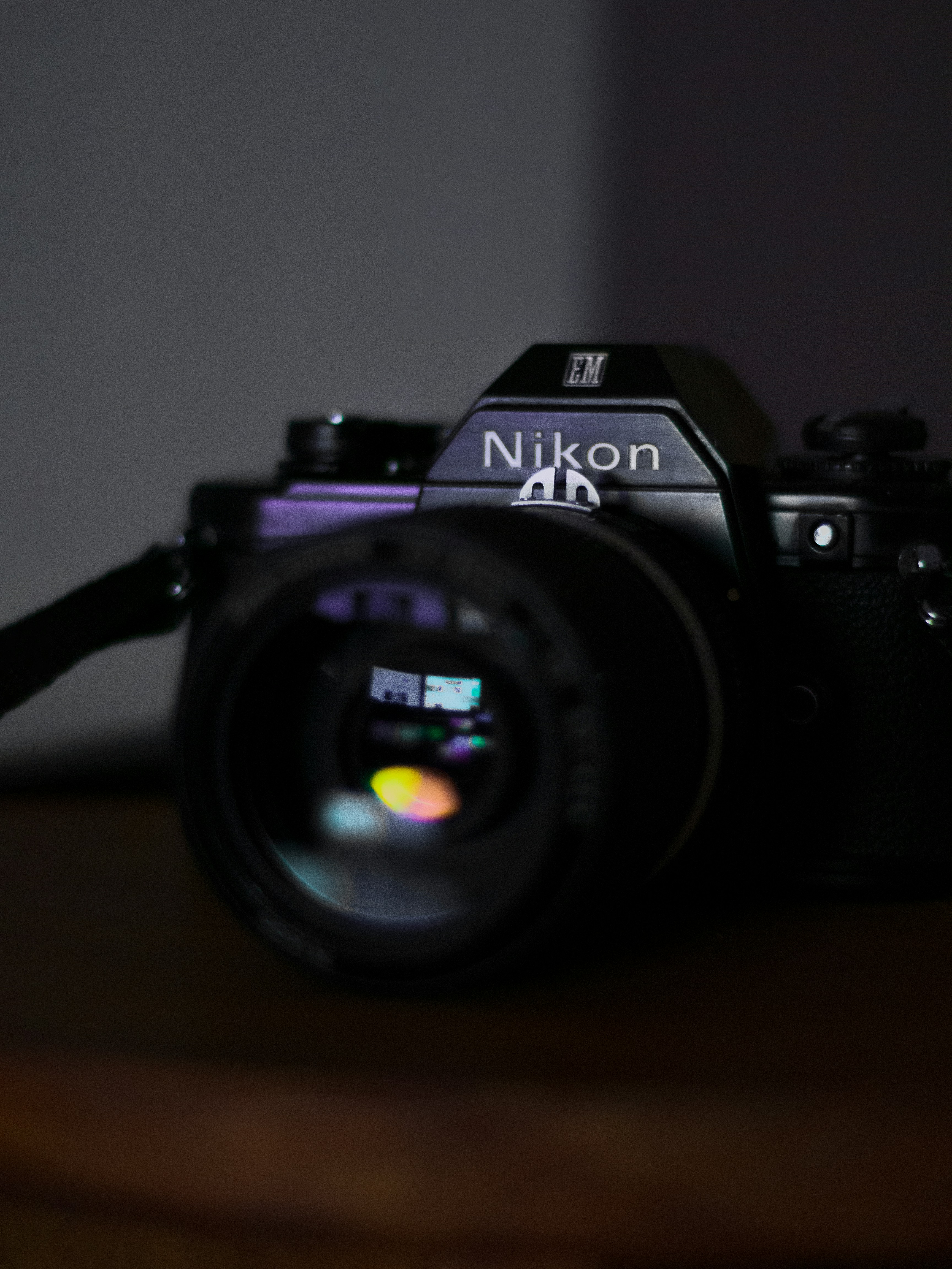 Close-up of a Nikon camera showcasing its intricate design and lens details against a softly blurred background.