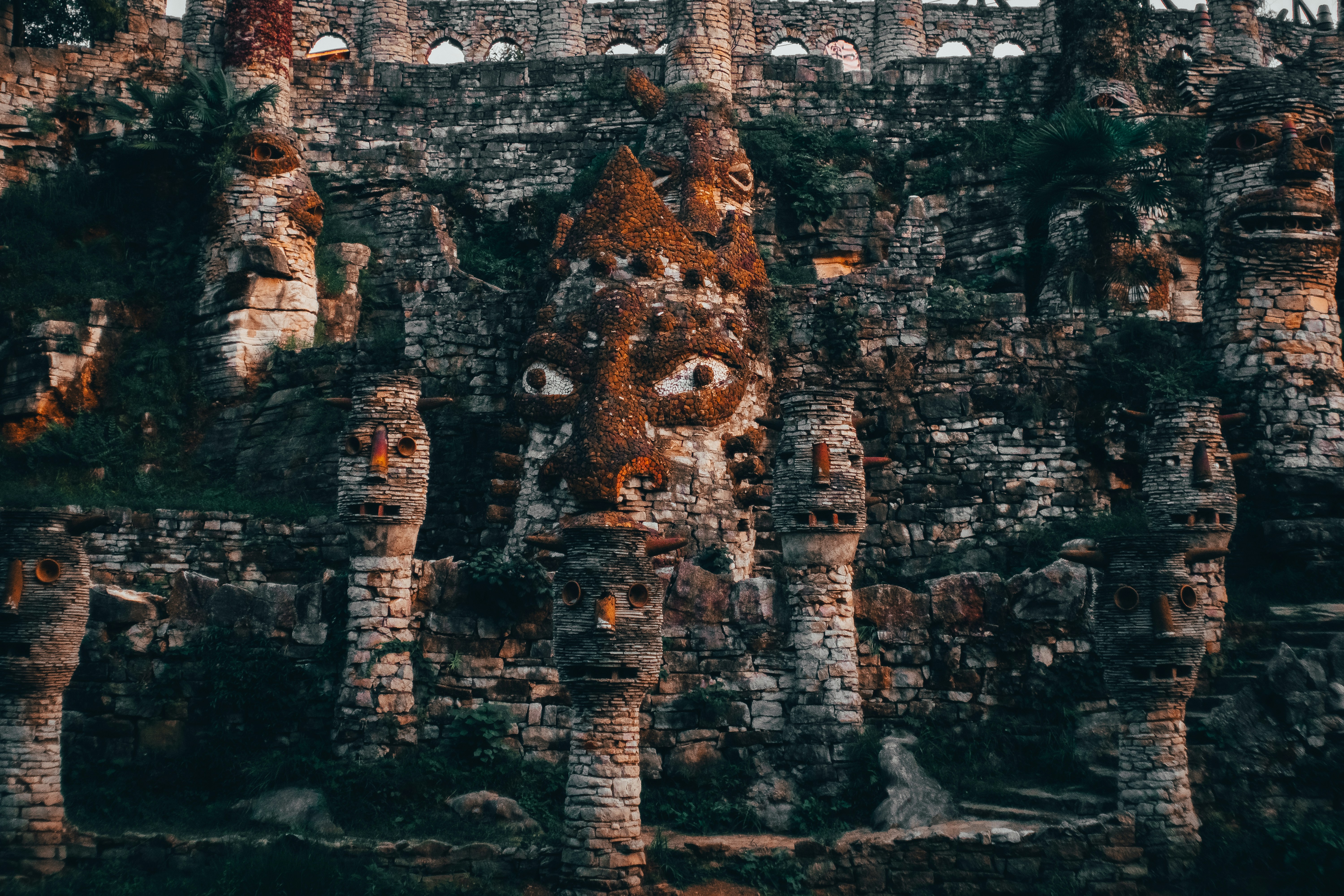A majestic stone face carved into a rocky wall, surrounded by towering pillars, evoking a sense of history and mystery.
