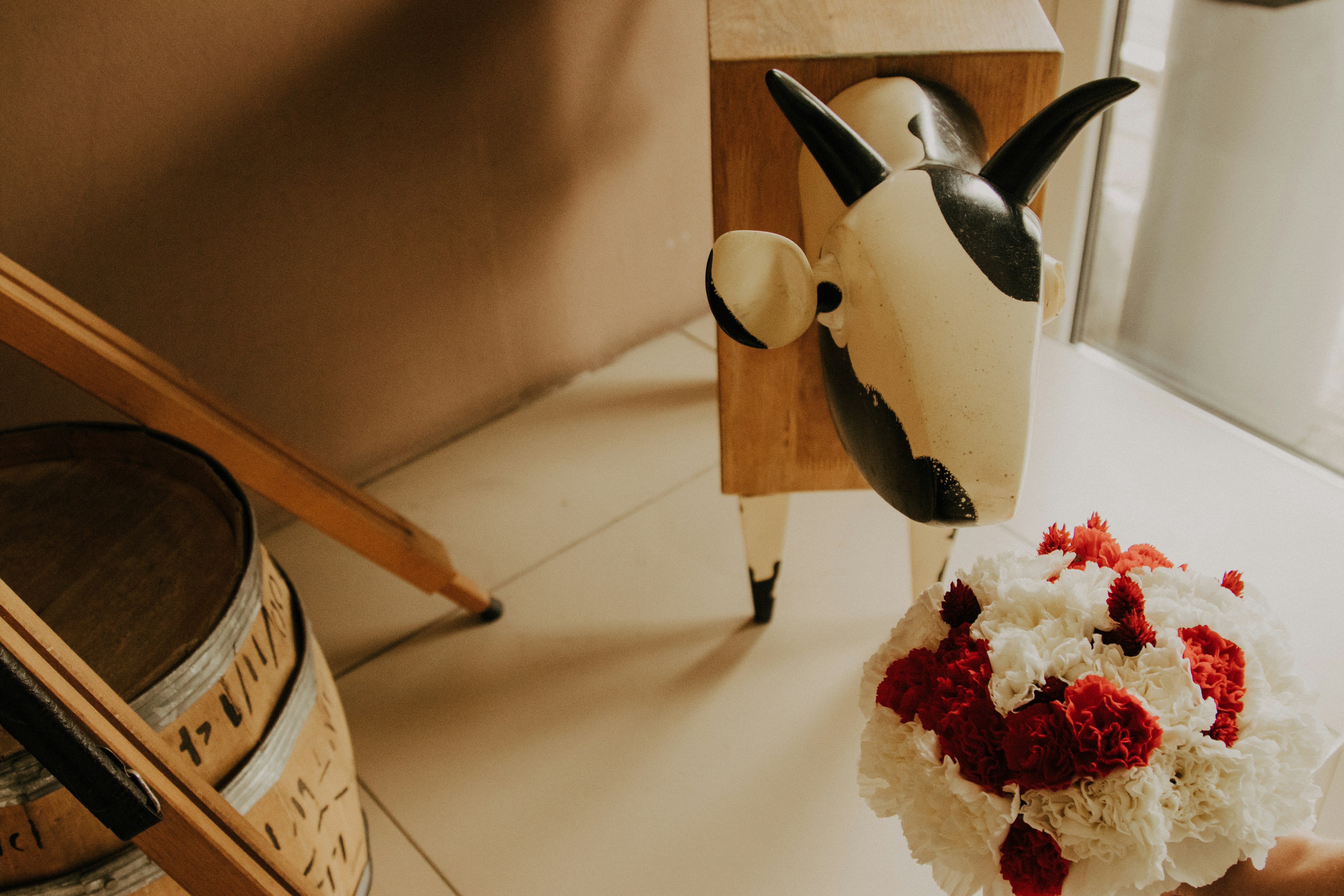 Penguin Figurine Keeps Watch Over a Crimson-White Bouquet in a Cozy Corner