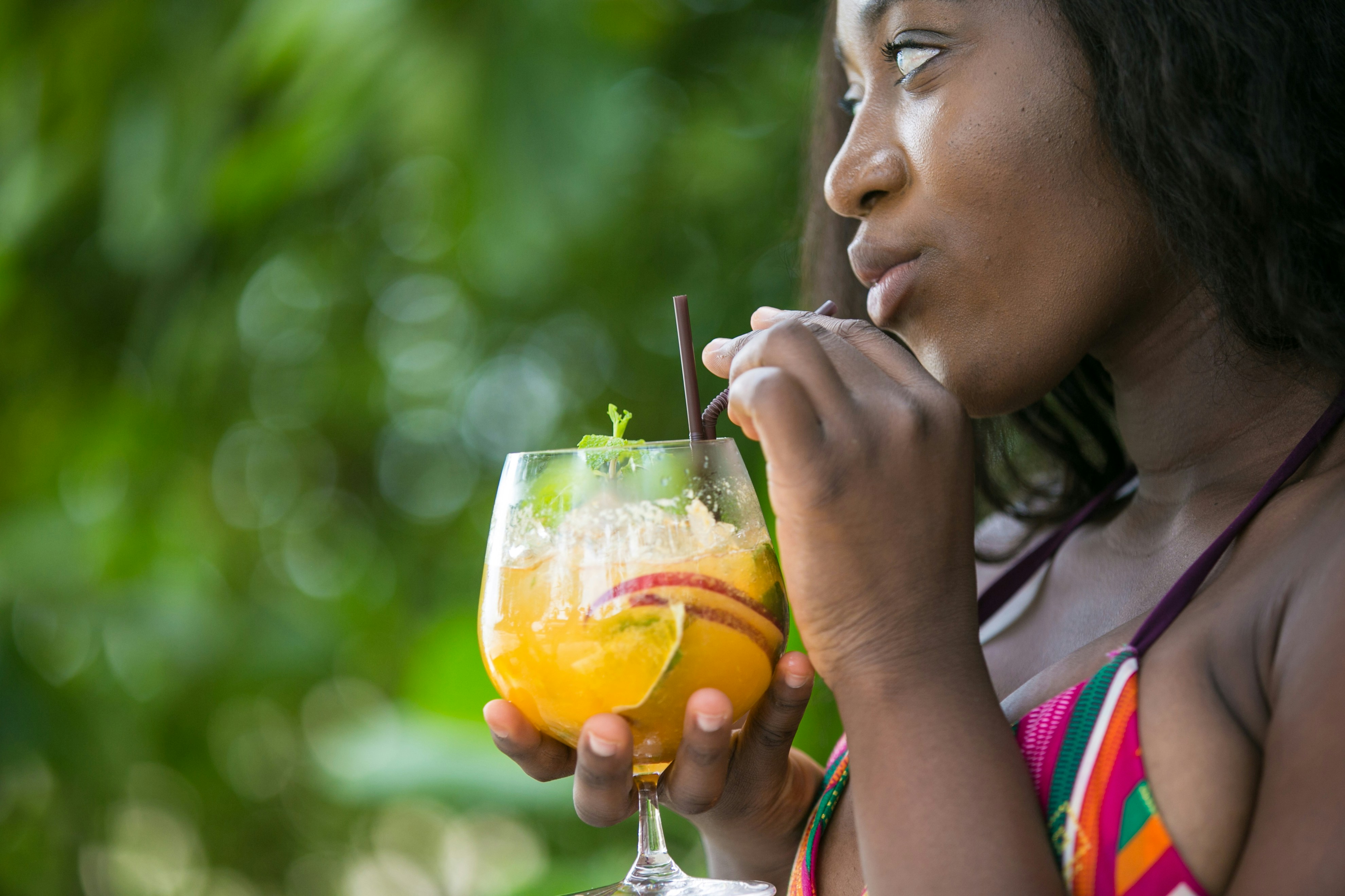 Woman drinking yellow liquid from clear drinking glass photo – Free Human Image on Unsplash