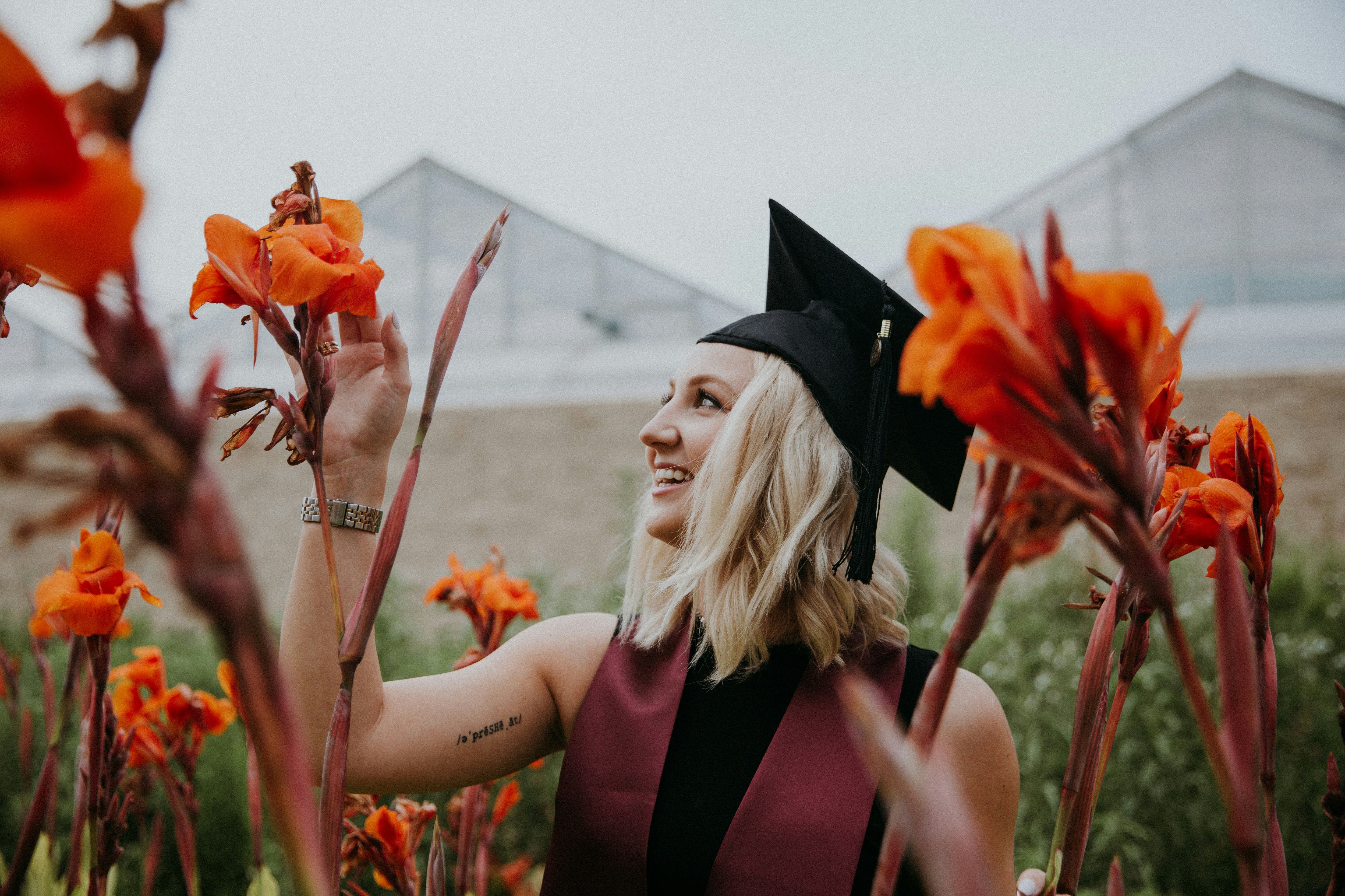 Woman in black academic dress holding orange flower photo – Free Flower ...