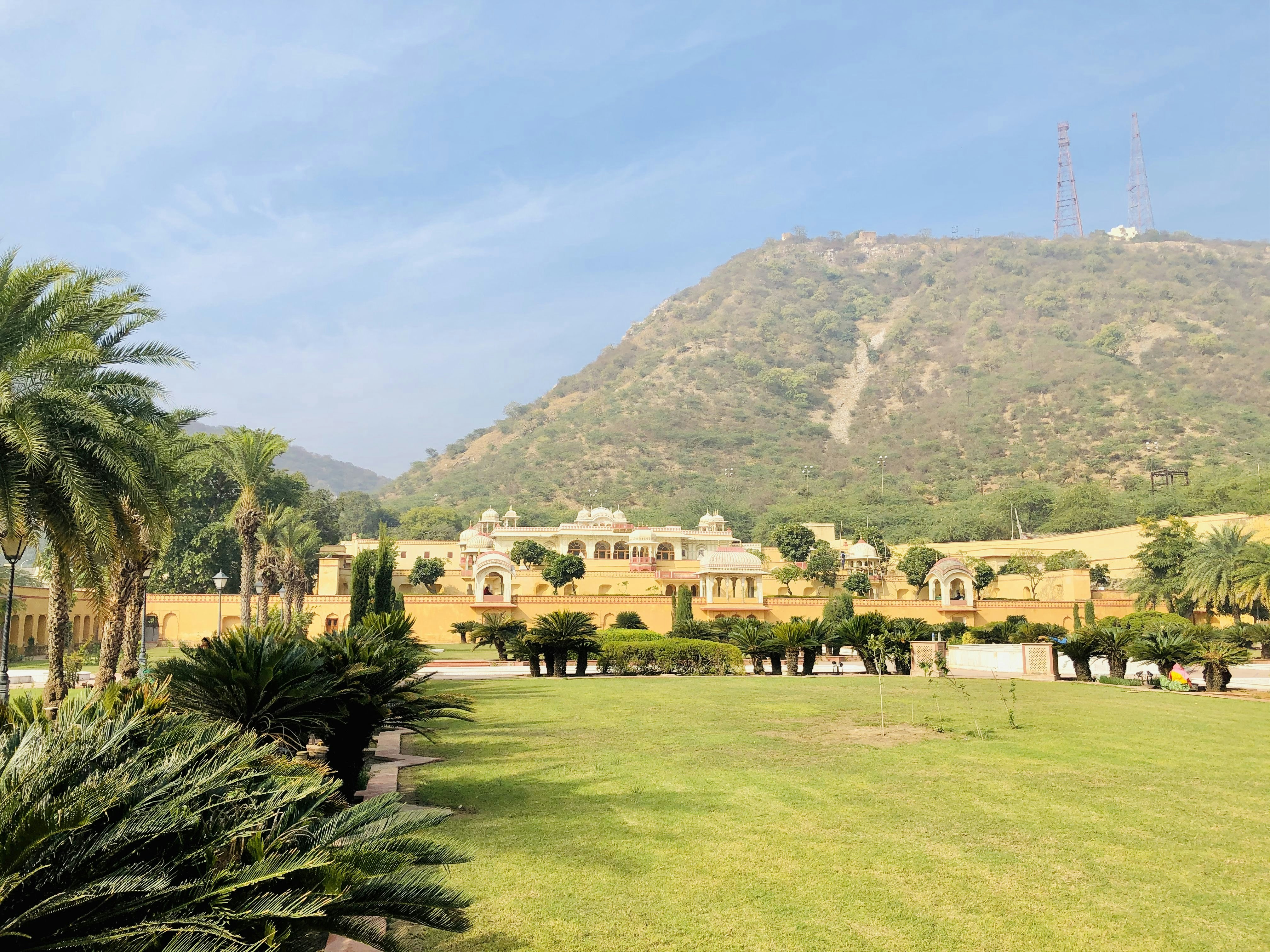 Sunlit Courtyard Framed by Palm Lanes and a Hilltop Villa