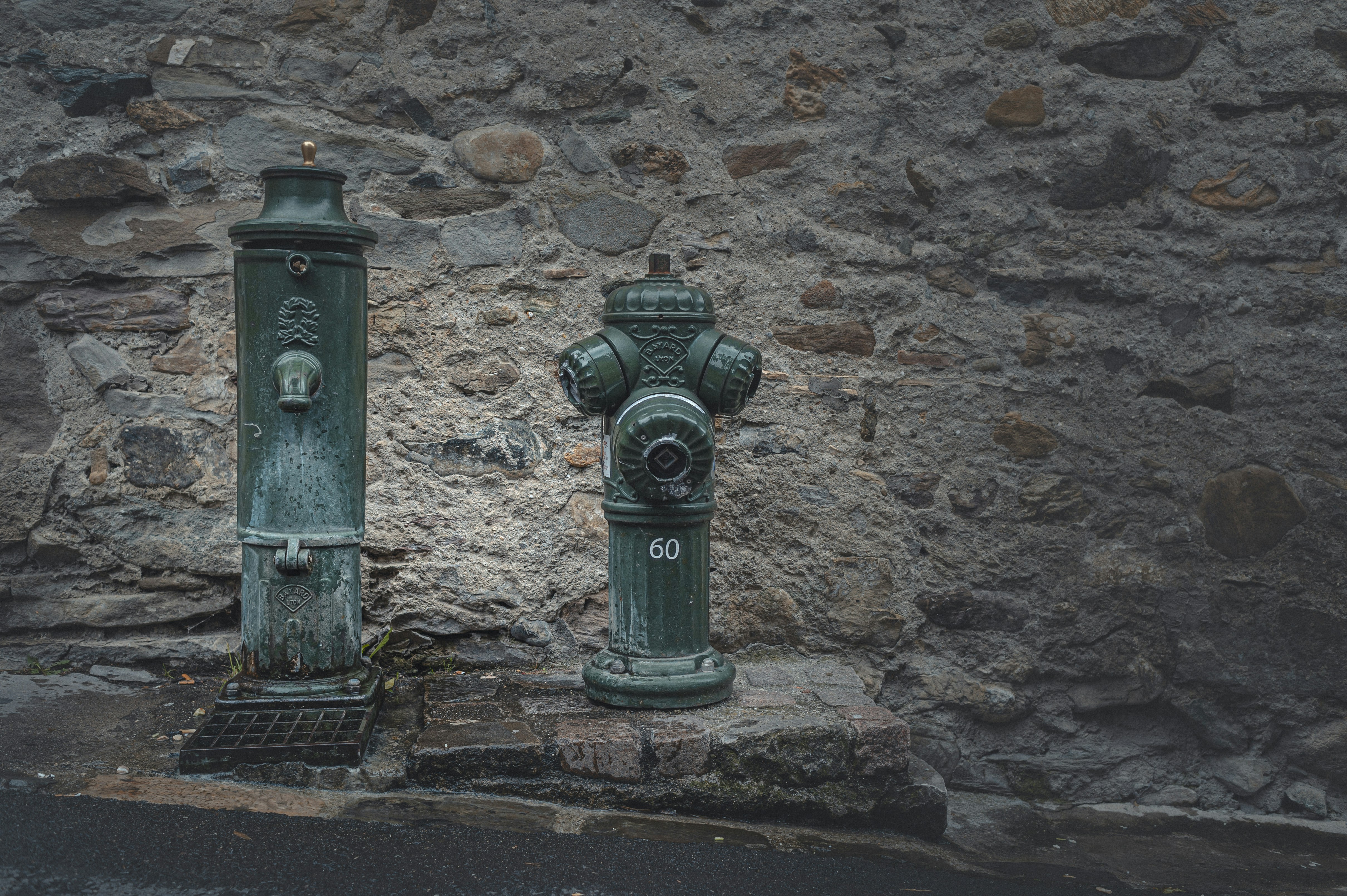 Black steel fire hydrant on brown concrete wall photo – Free Grey Image ...