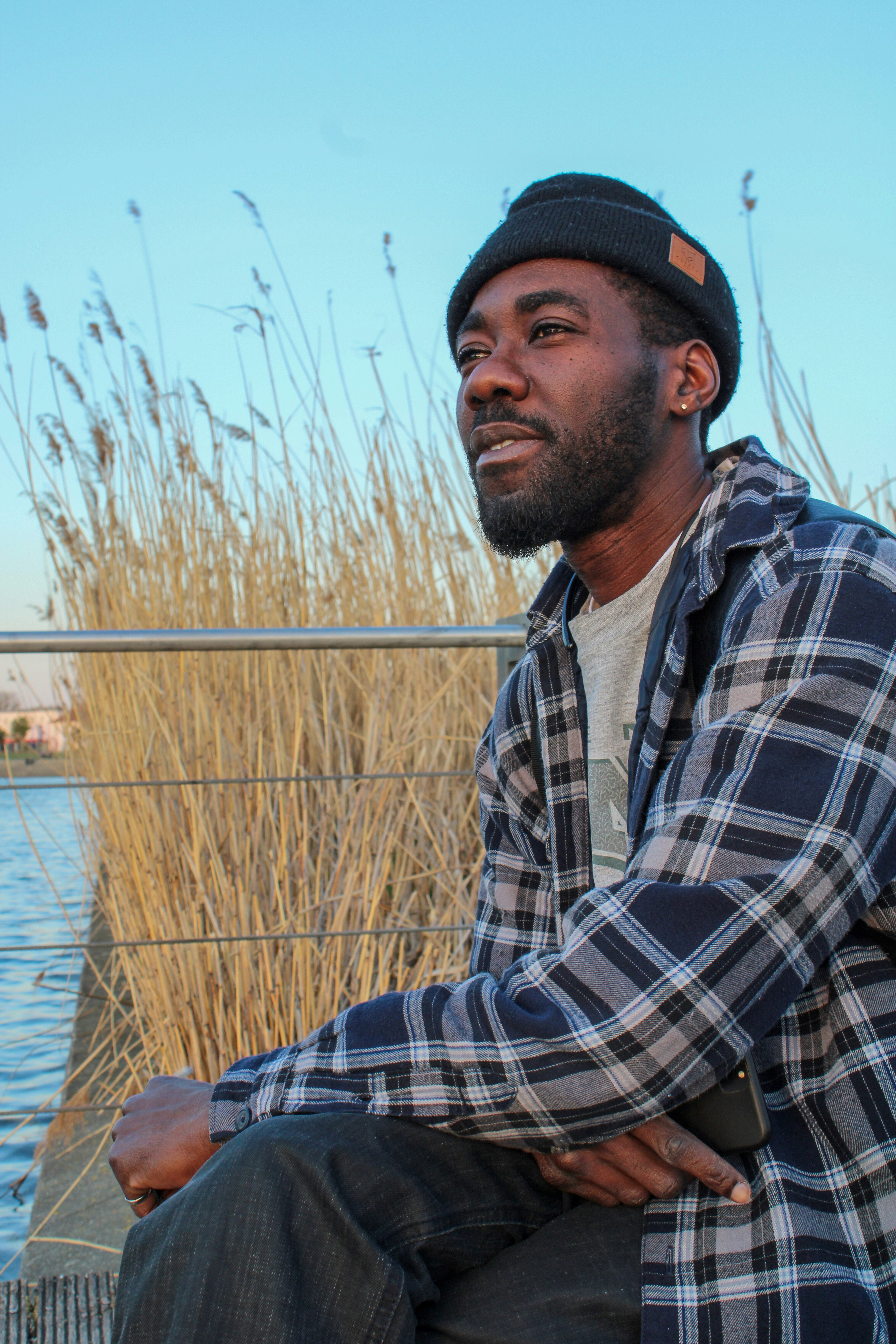 man in blue white and black plaid dress shirt wearing black cap