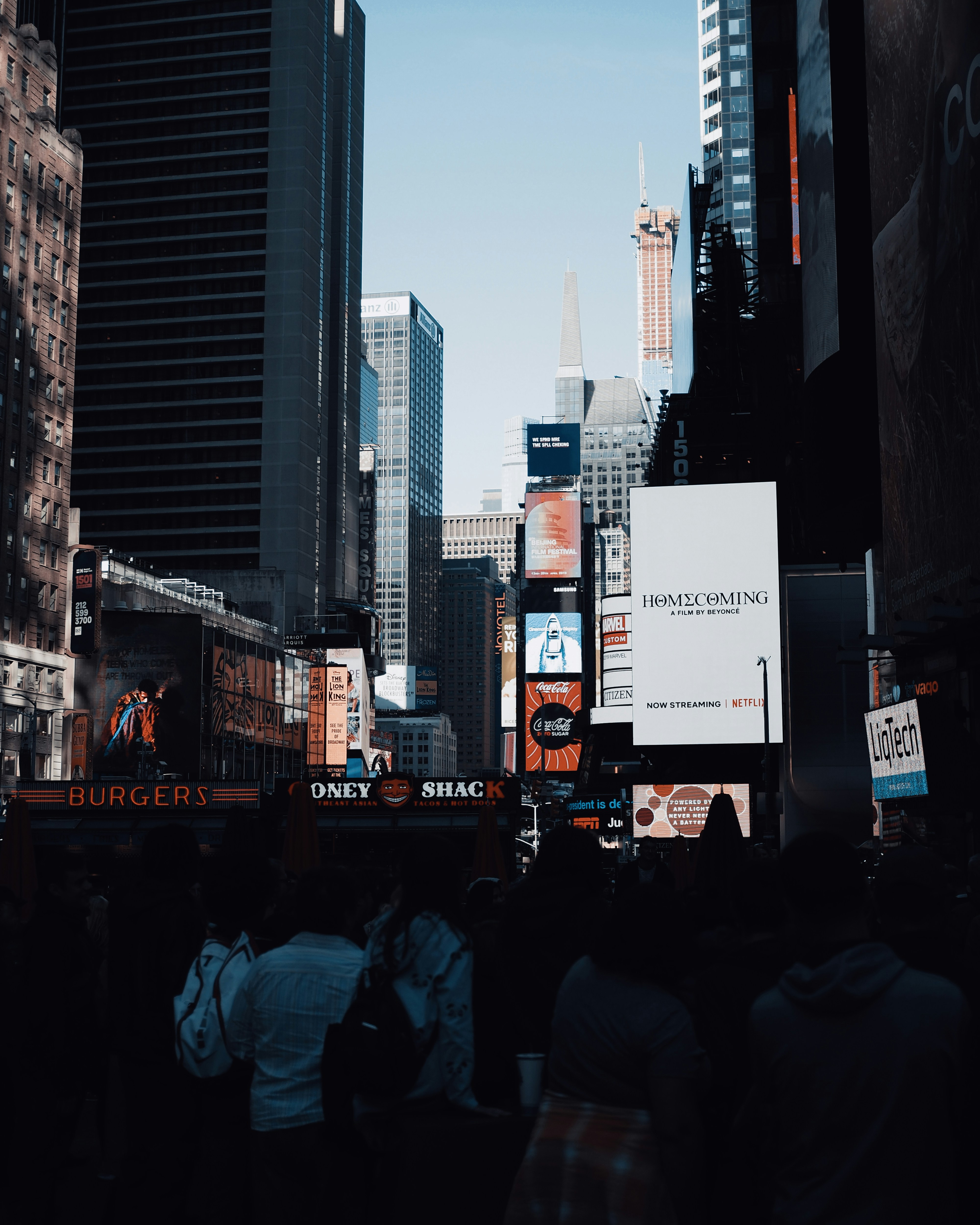Neon Crossroads: Crowds Beneath the City's Digital Canvases