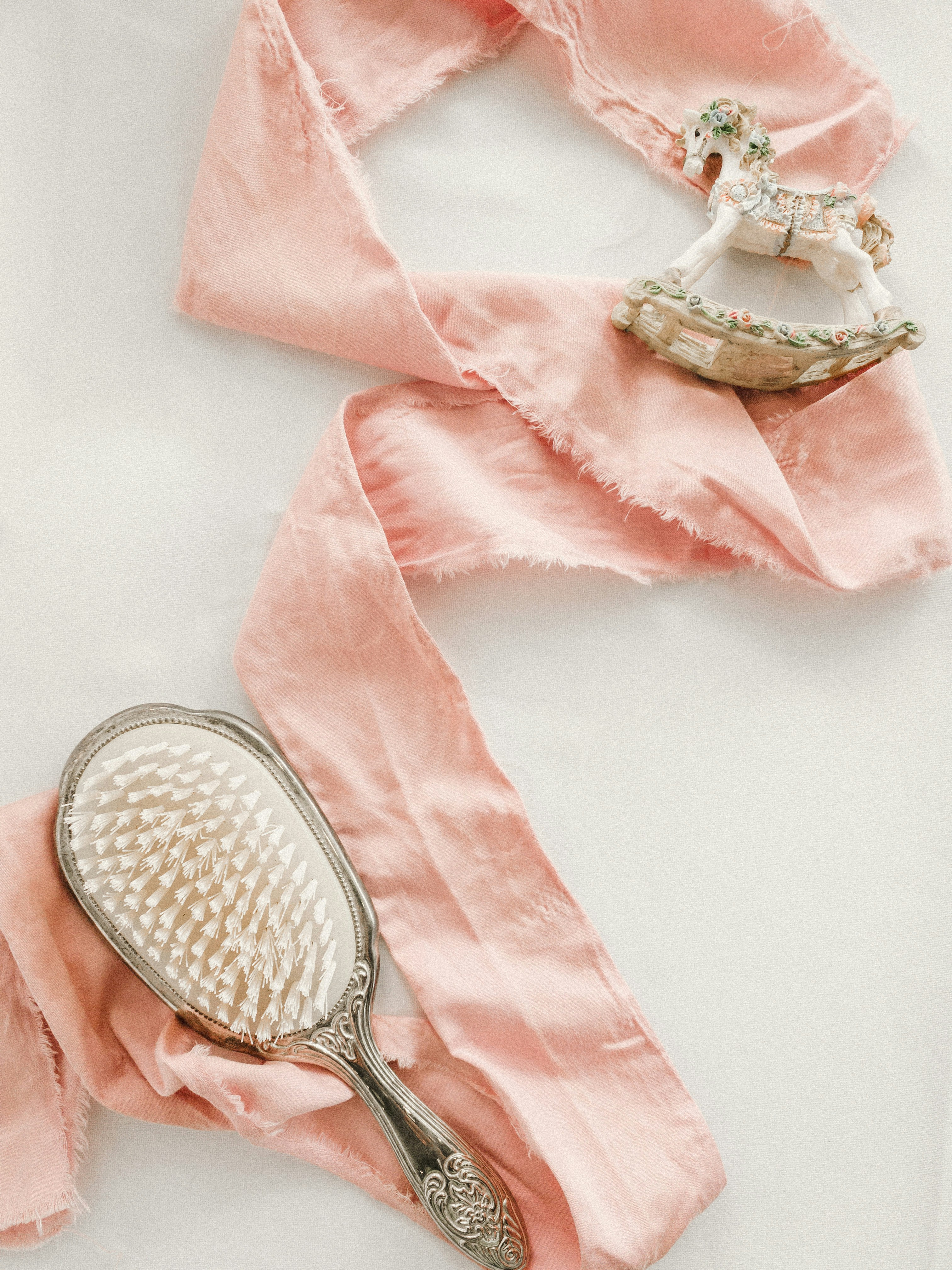 Whispers of Pink: A Quiet Still-Life with Fabric, a Silver Brush, and a Toy Rocking Horse