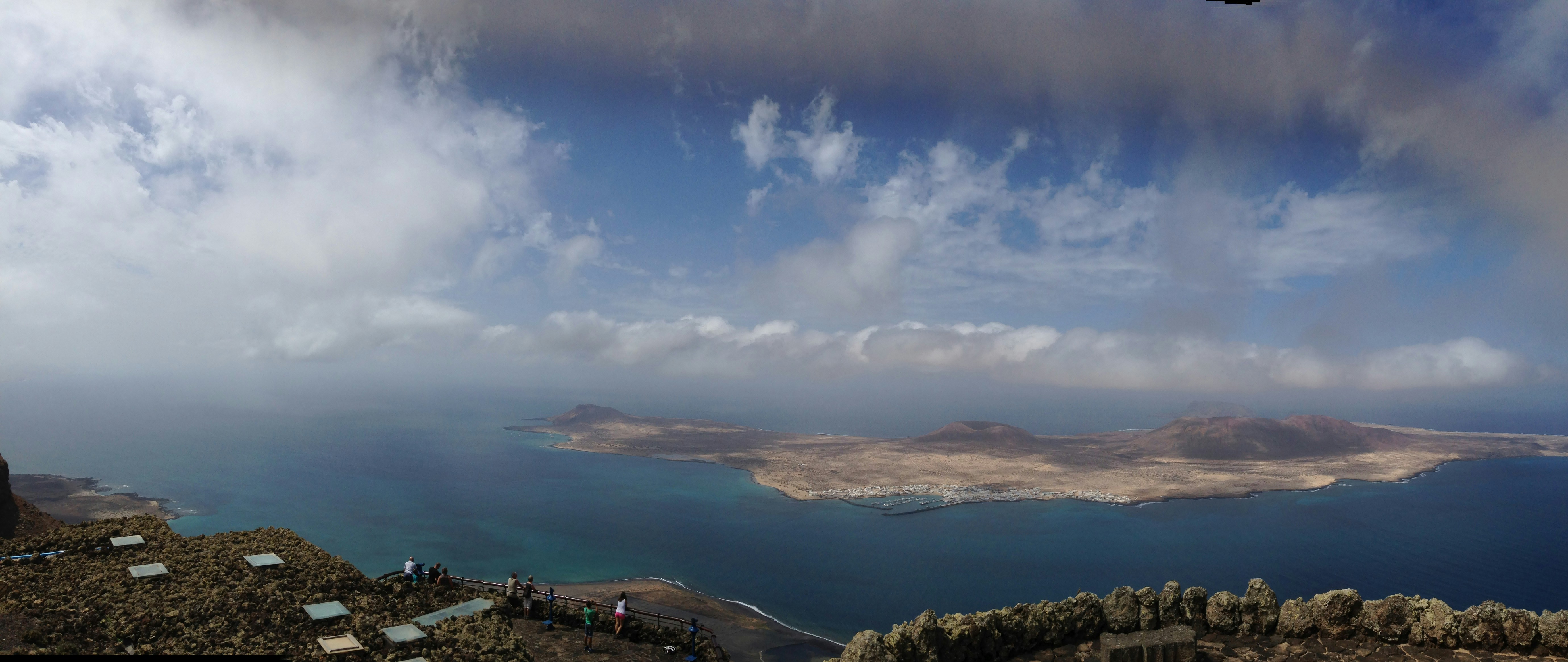 Terraced Cliffs Over a Sapphire Sea with Distant Volcanic Islets