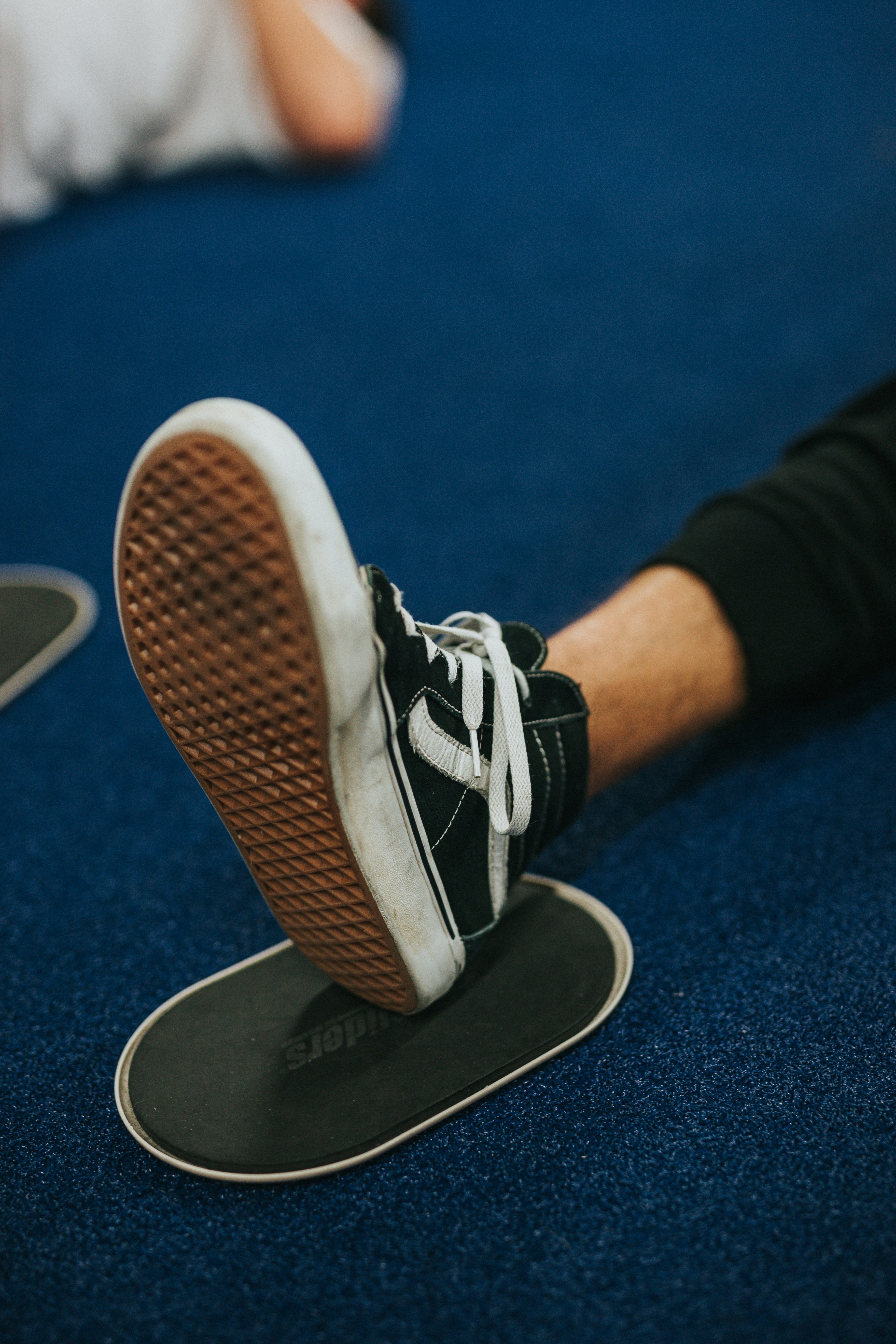 Kickflip of Focus: A Solo Shoe in Motion on Blue Carpet