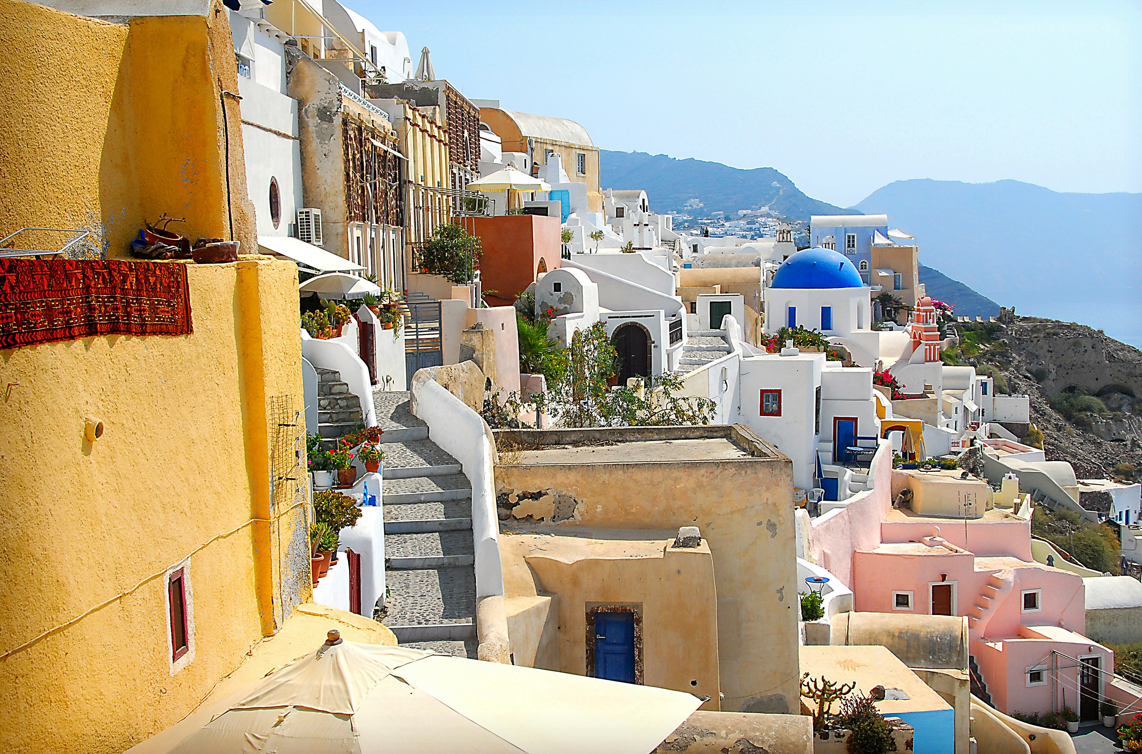 Colorful hillside architecture with iconic blue domes under a clear sky.