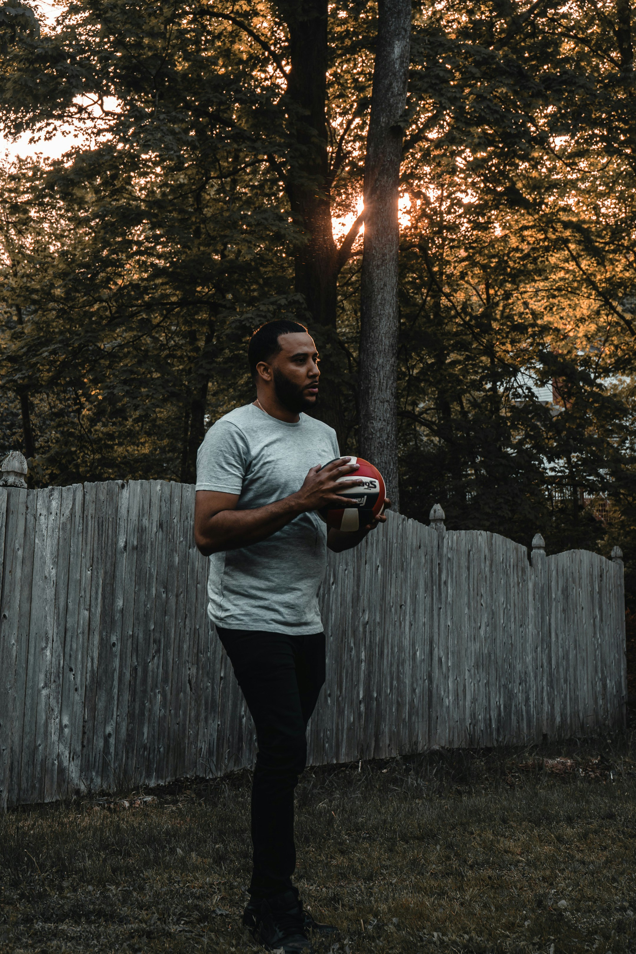 Holding the Sky: A Quiet Moment with a Footballer in the Yard