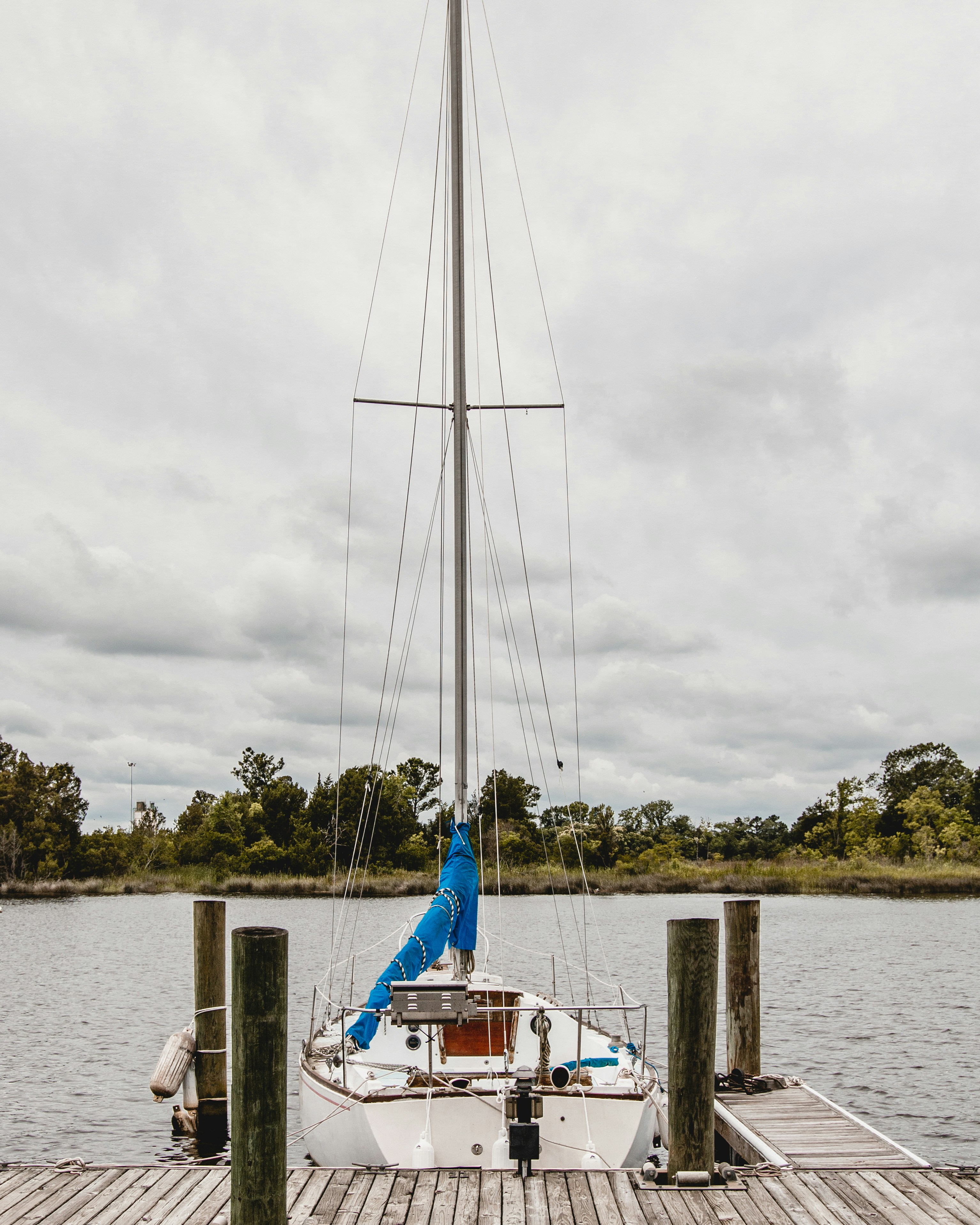 White and blue sailboat on sea under gray clouds photo – Free Grey ...