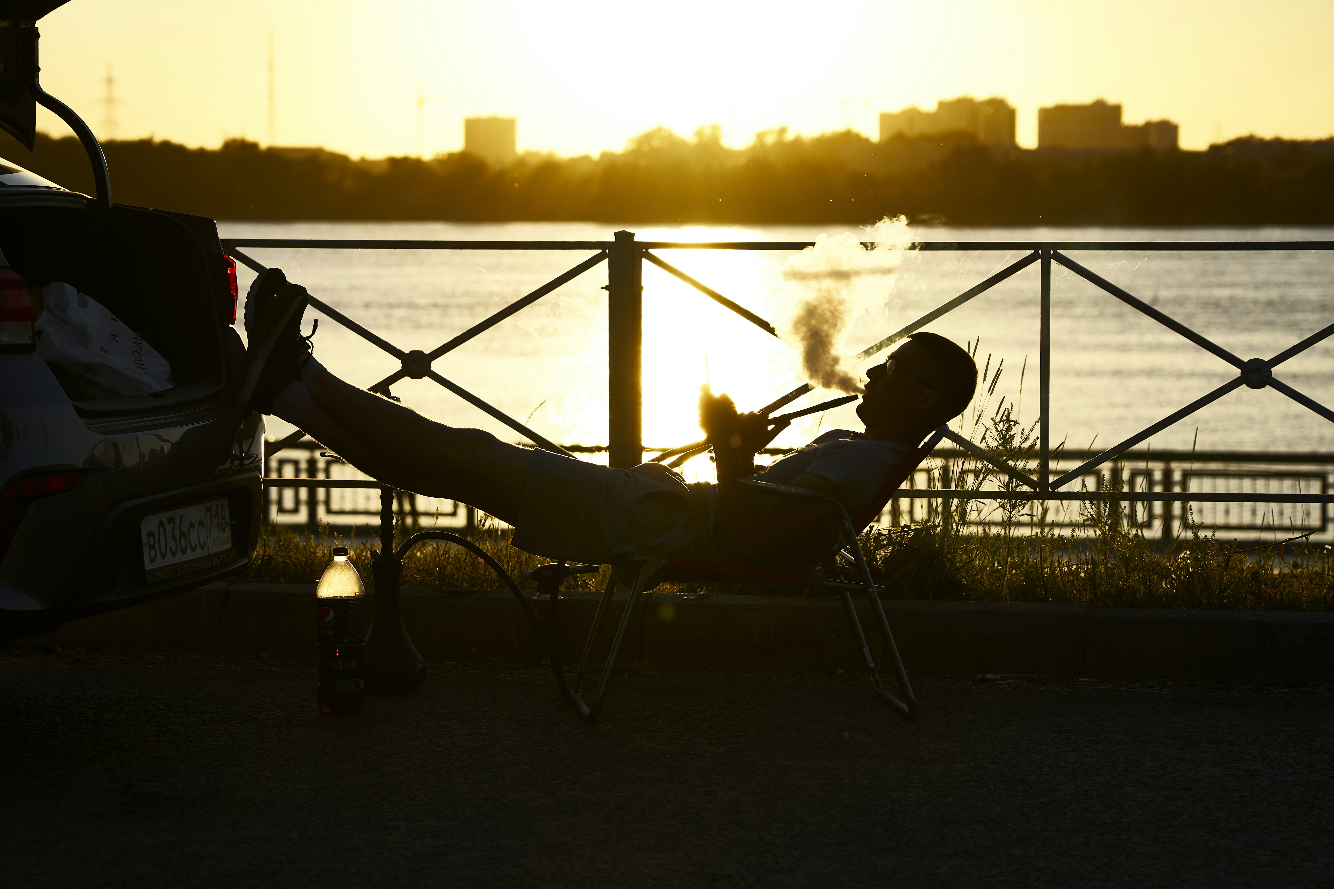 man and woman sitting on folding chairs near body of water during daytime