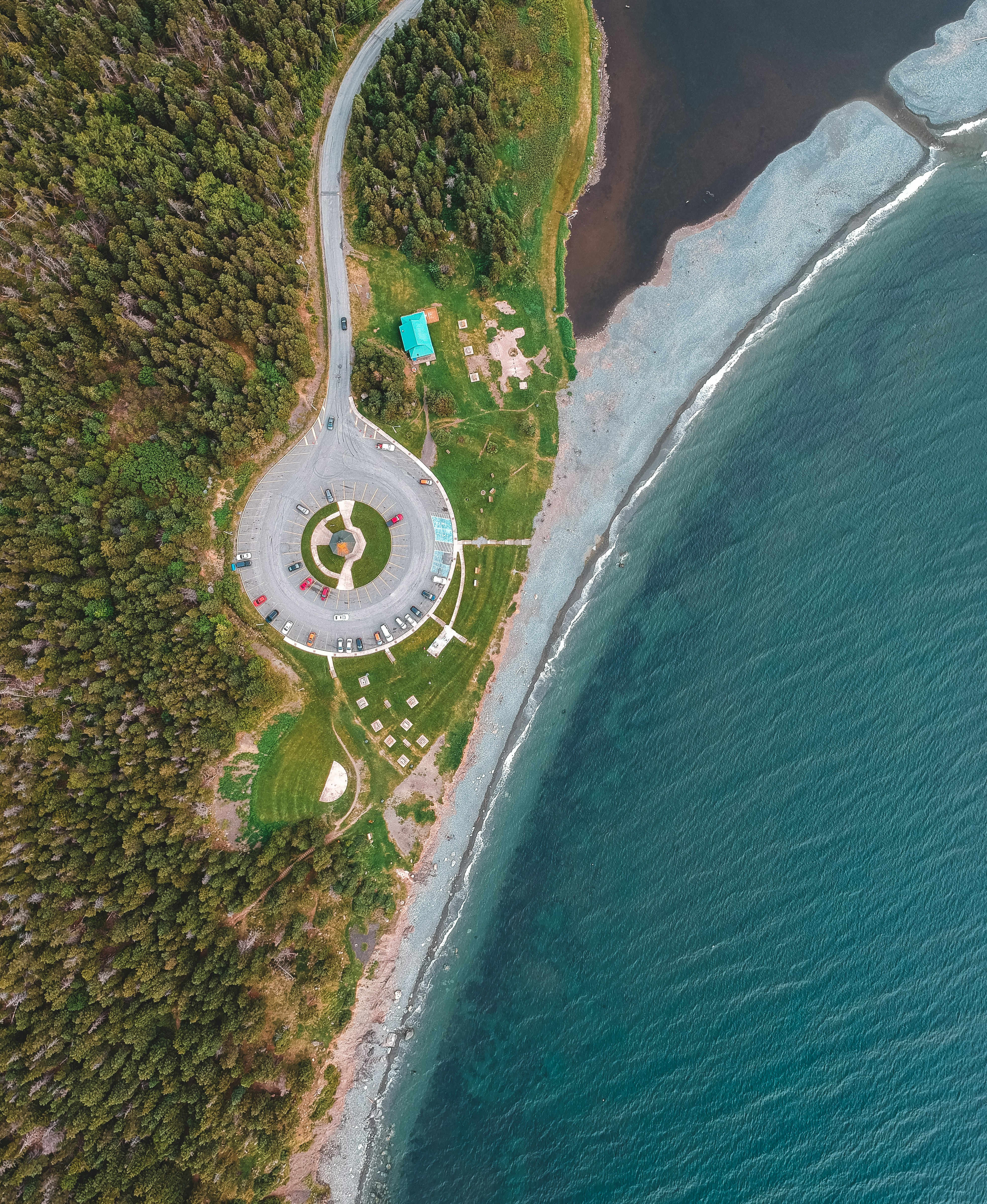 Circular Haven at the Coast: Aerial View of a Ring Road Nestled Between Forest and Ocean