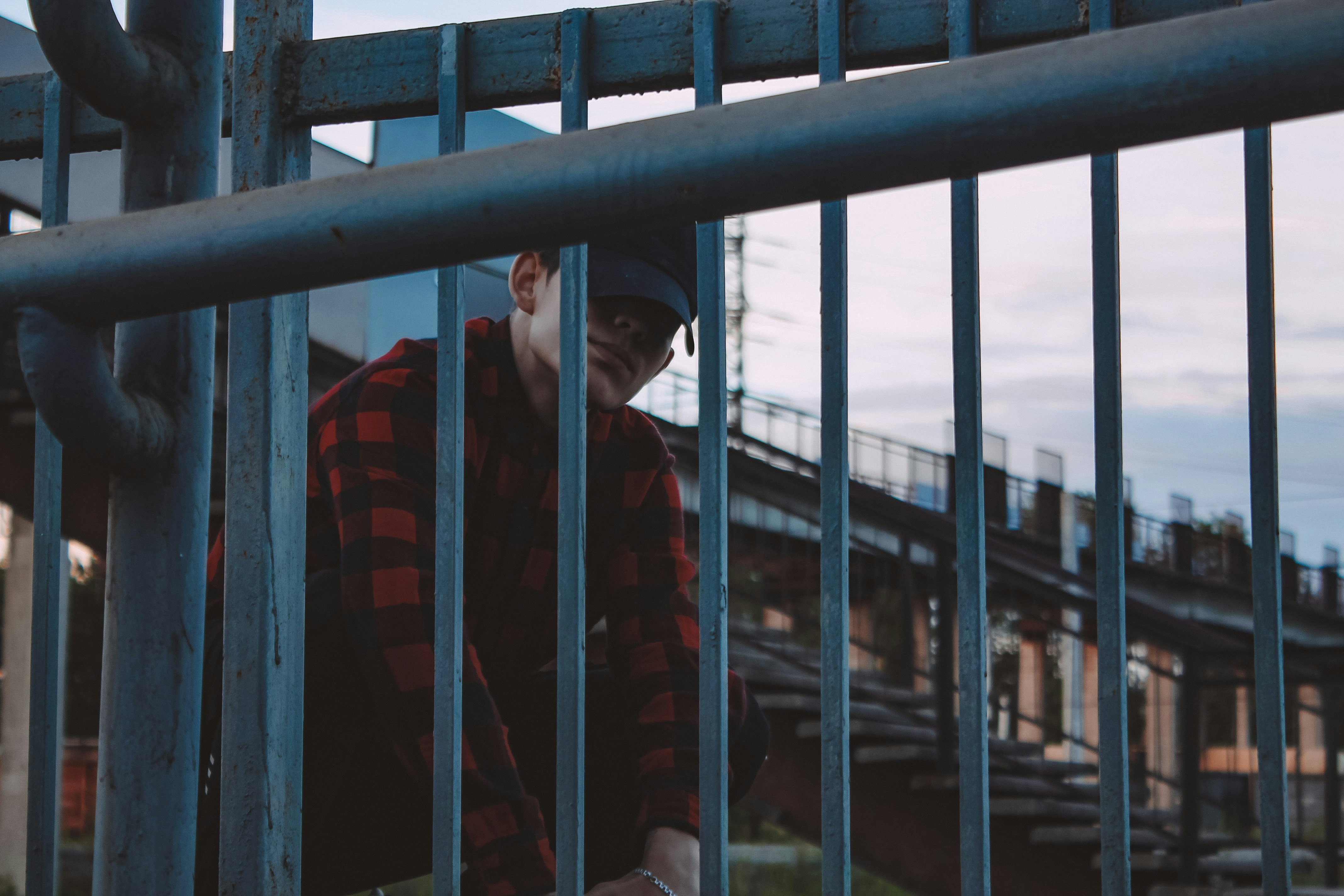 Man in red and black plaid dress shirt standing near railings photo ...