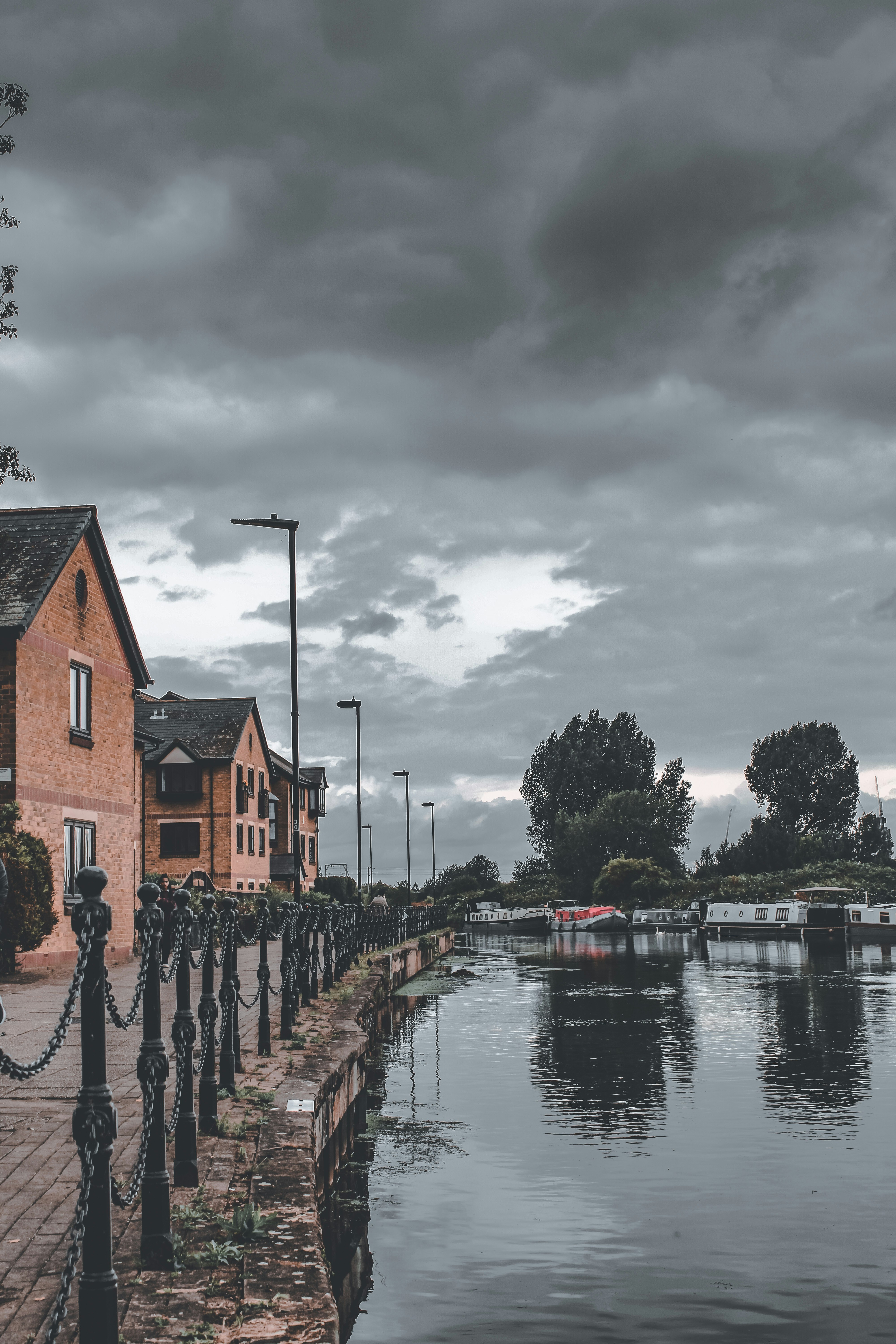 brown and white concrete houses beside river under gray clouds