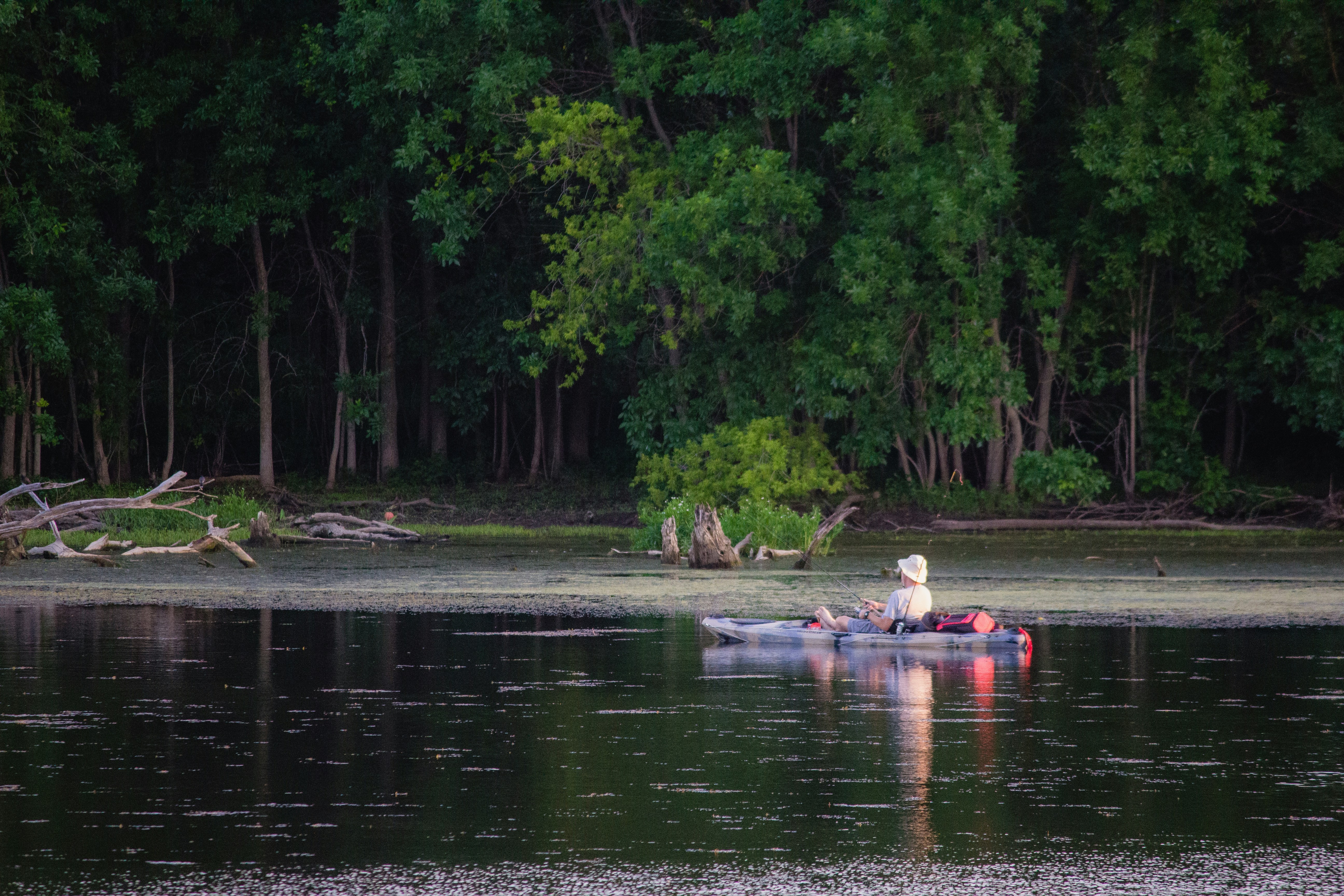 Fisherman relaxing on a pond in a canoe