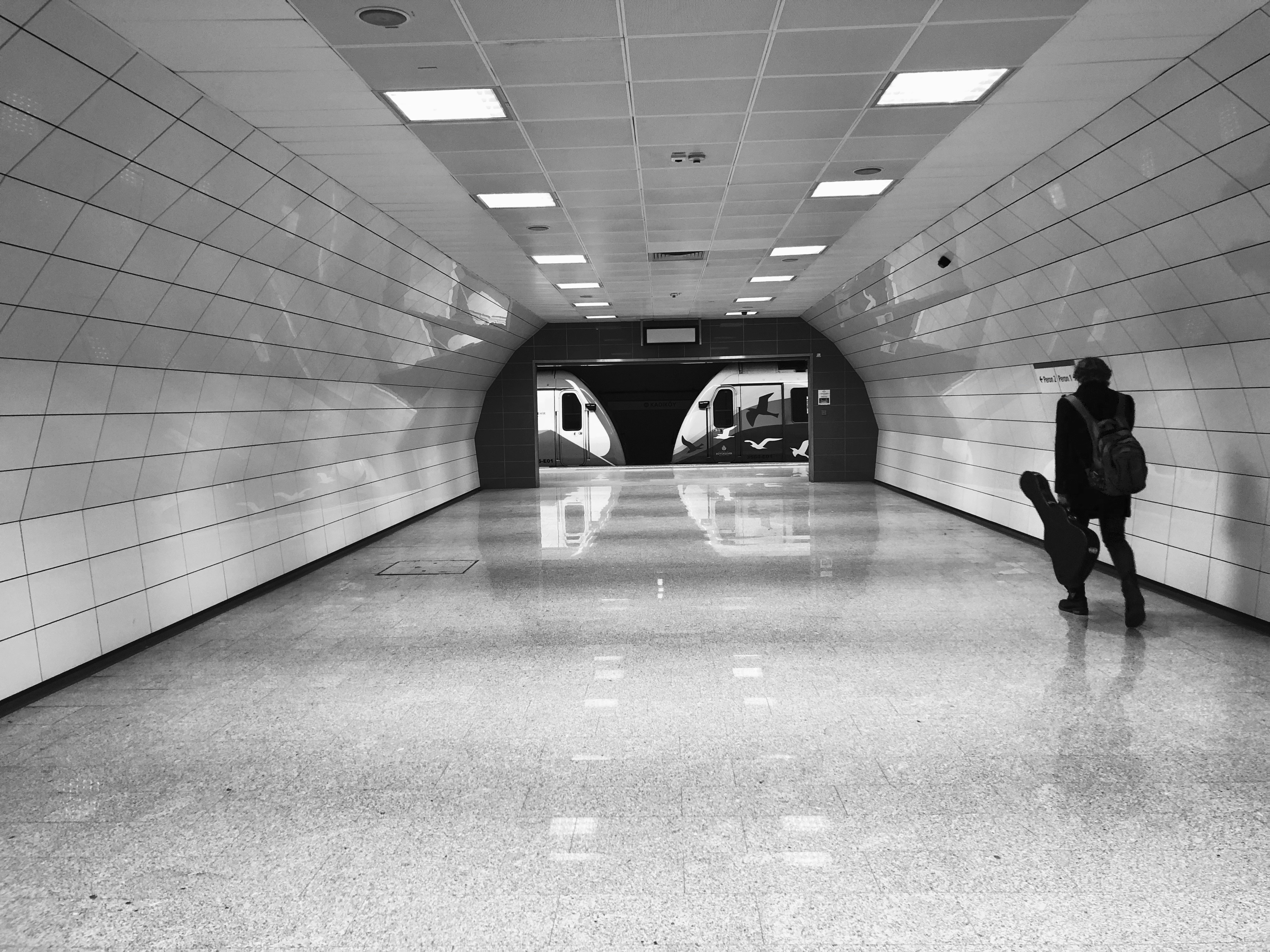 grayscale photo of people walking on hallway