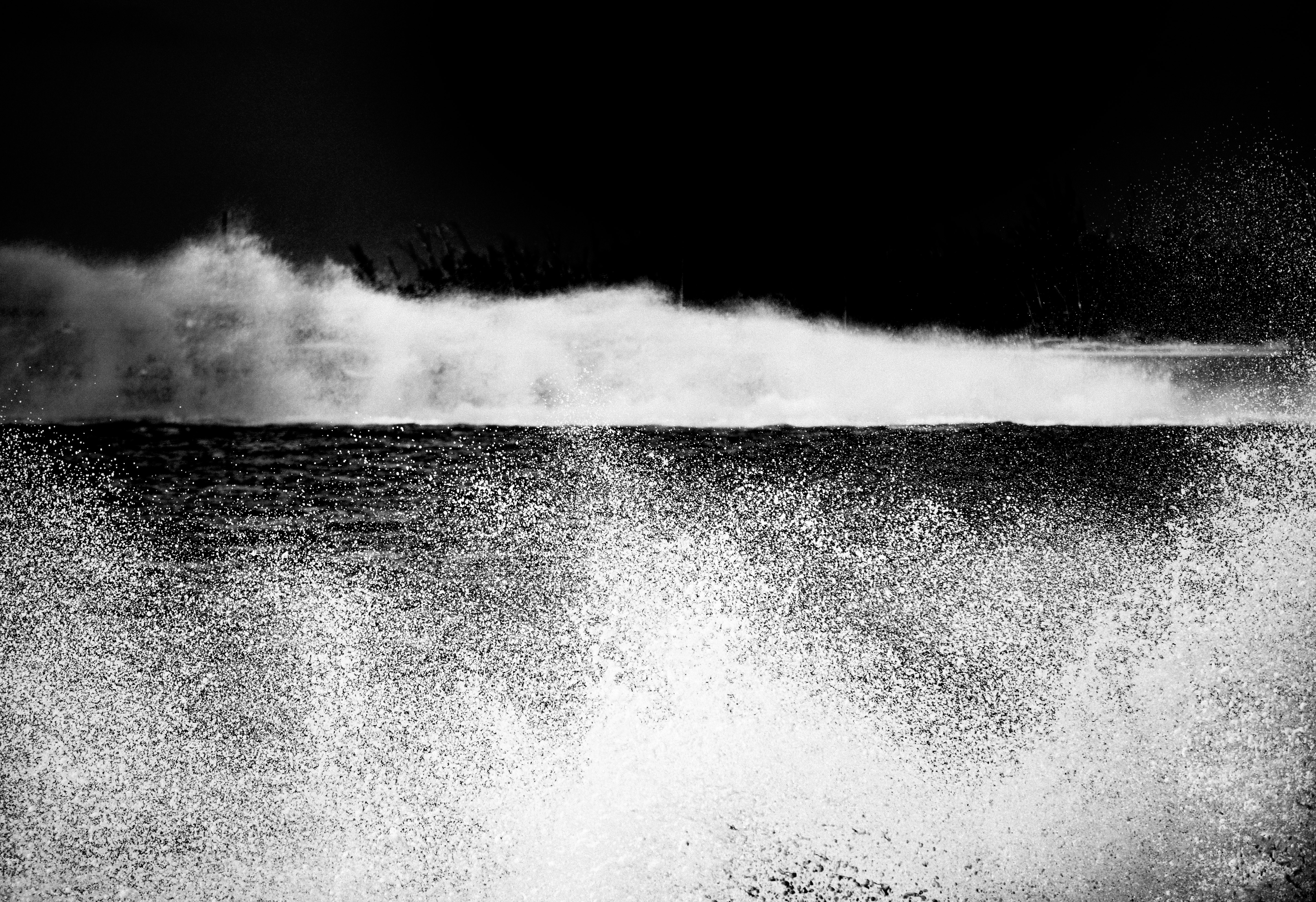 Dynamic waves crashing against a dark backdrop, creating a dramatic contrast in texture and motion.