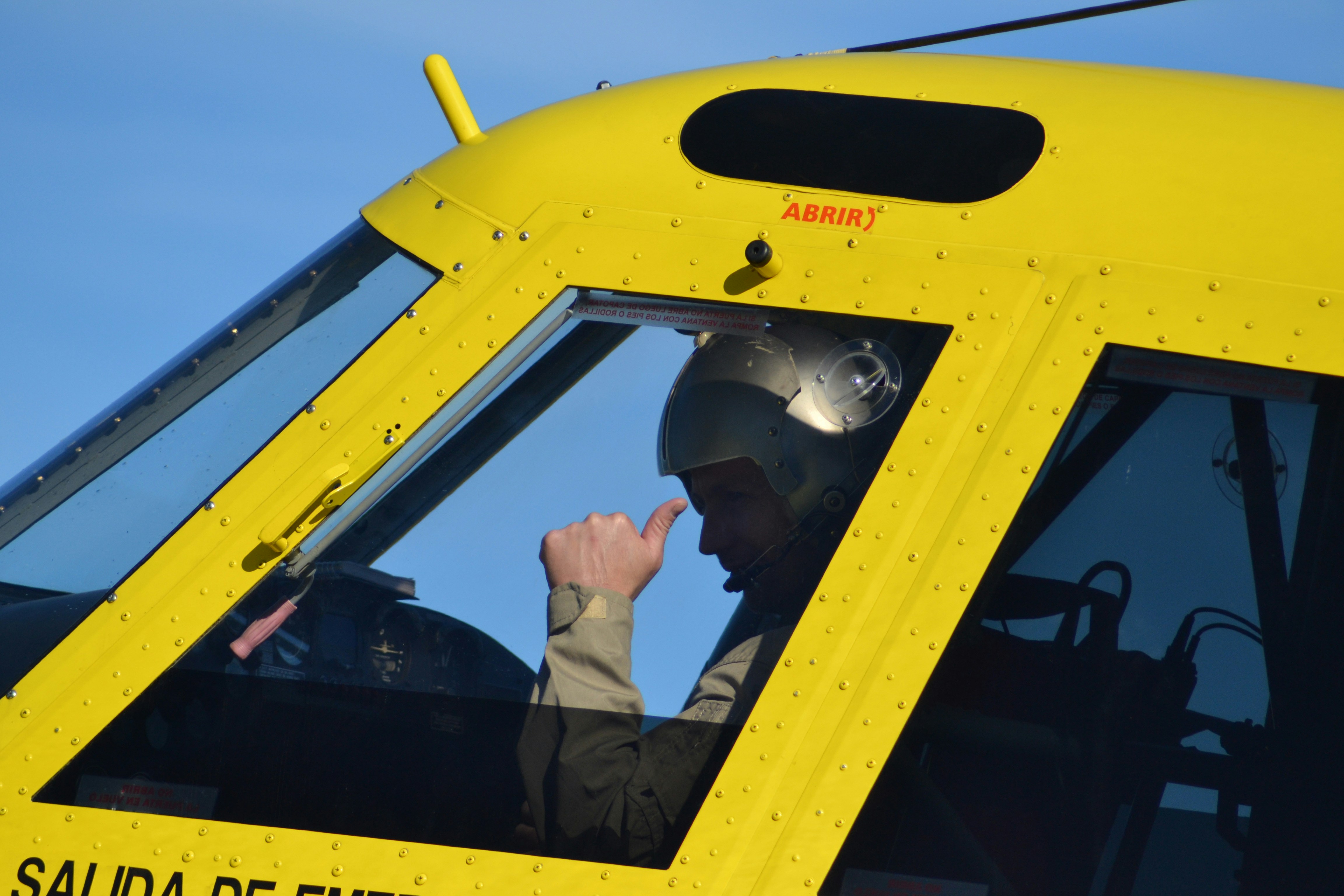 Thumbs-Up in a Sunlit Yellow Helicopter Cockpit