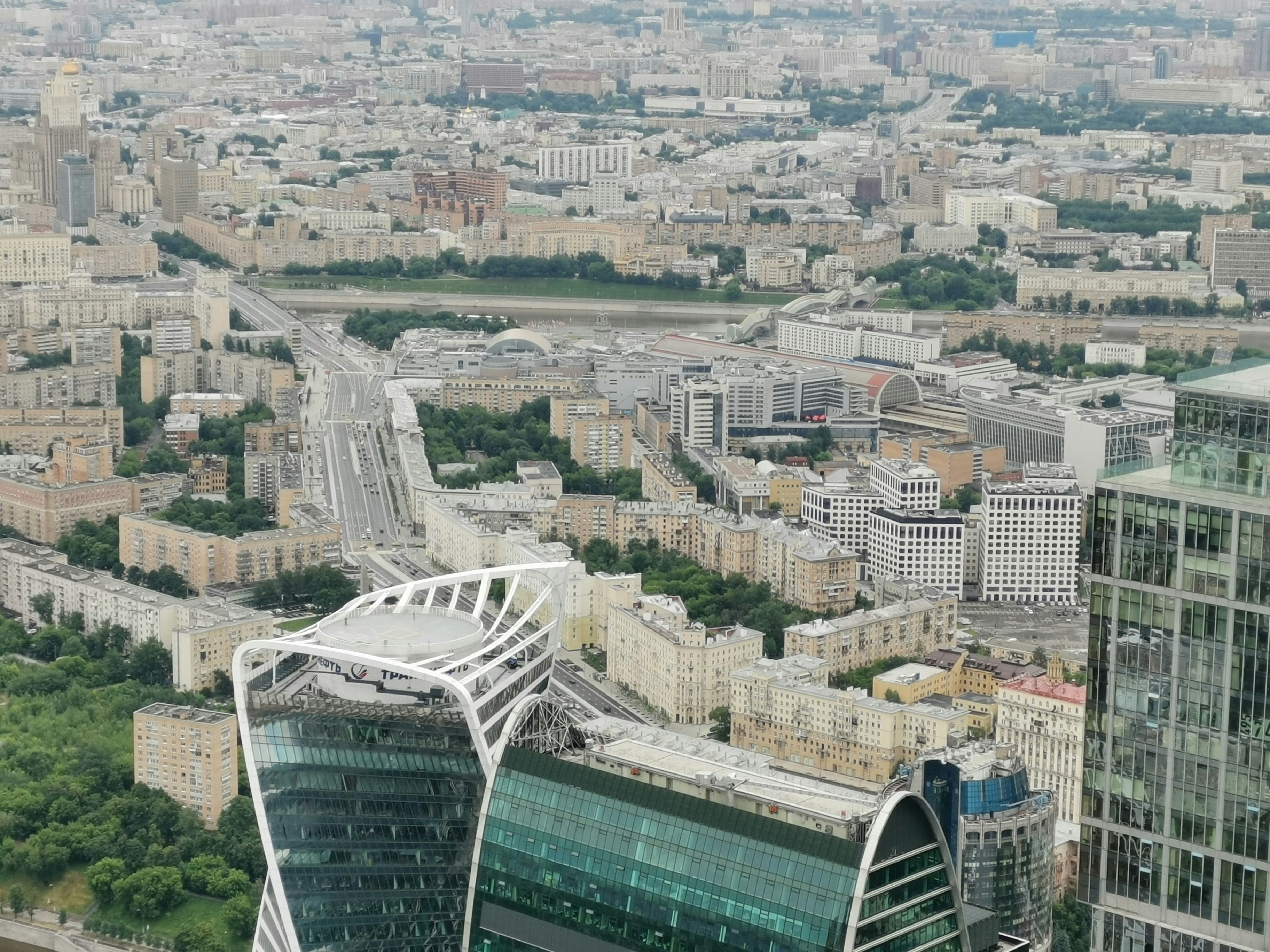 Aerial view capturing the intricate layout of a bustling city, showcasing modern architecture and greenery interspersed throughout.