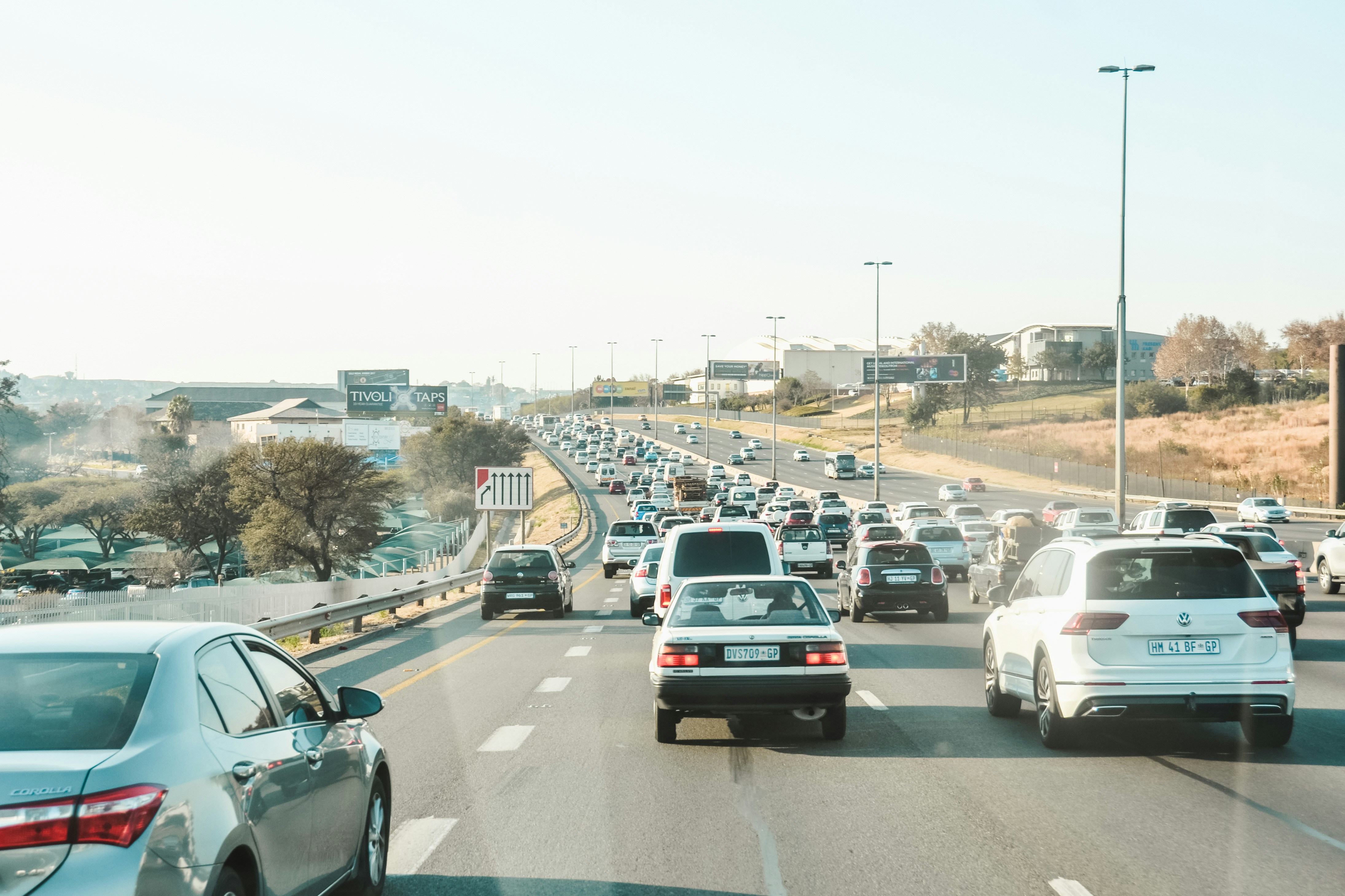 Busy highway filled with a variety of cars during daylight hours, showcasing the rhythm of urban transportation.