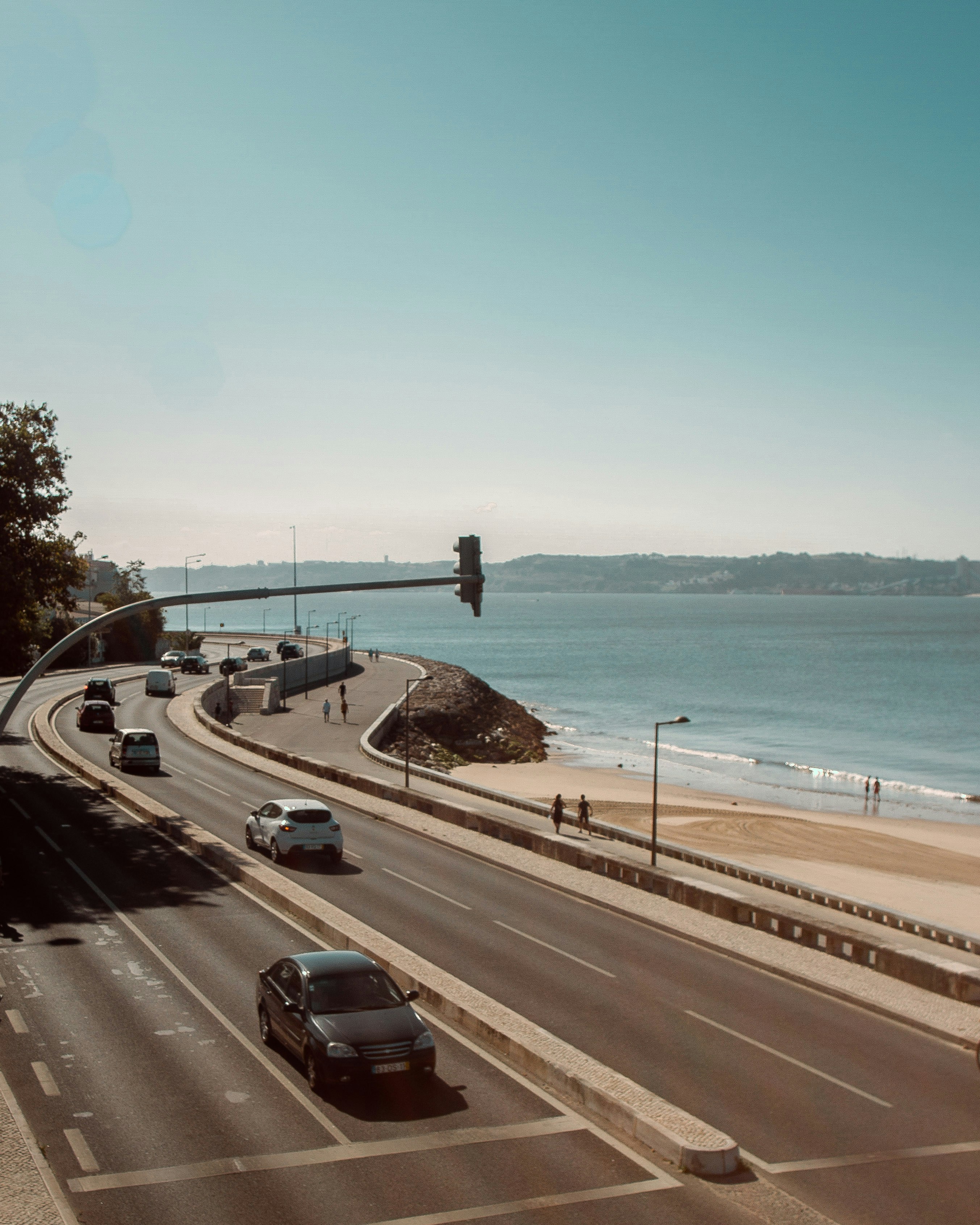 Coastal Curve: Sunlit Highway by a Quiet Bay