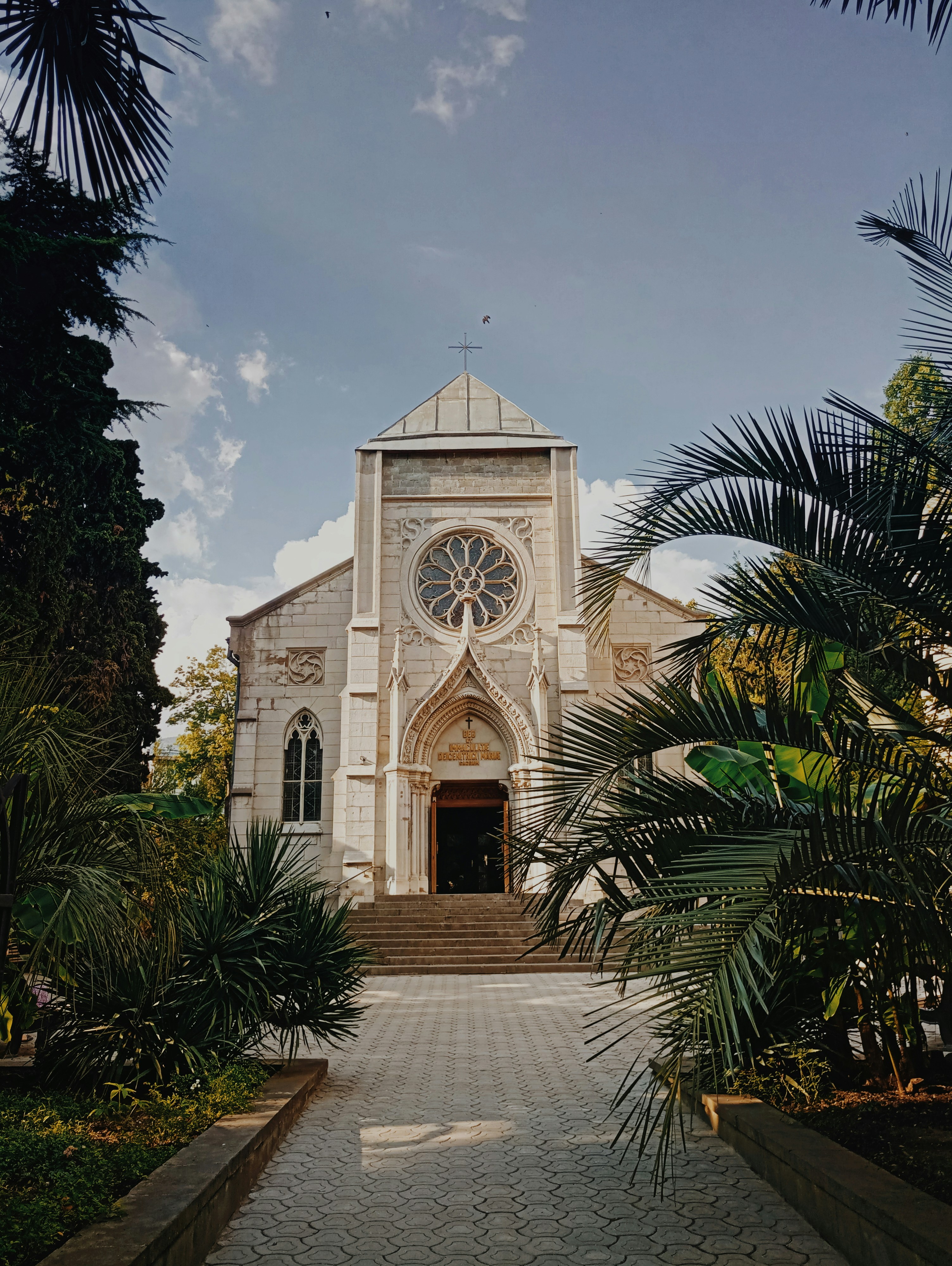Beige concrete church near green palm trees under blue sky during ...