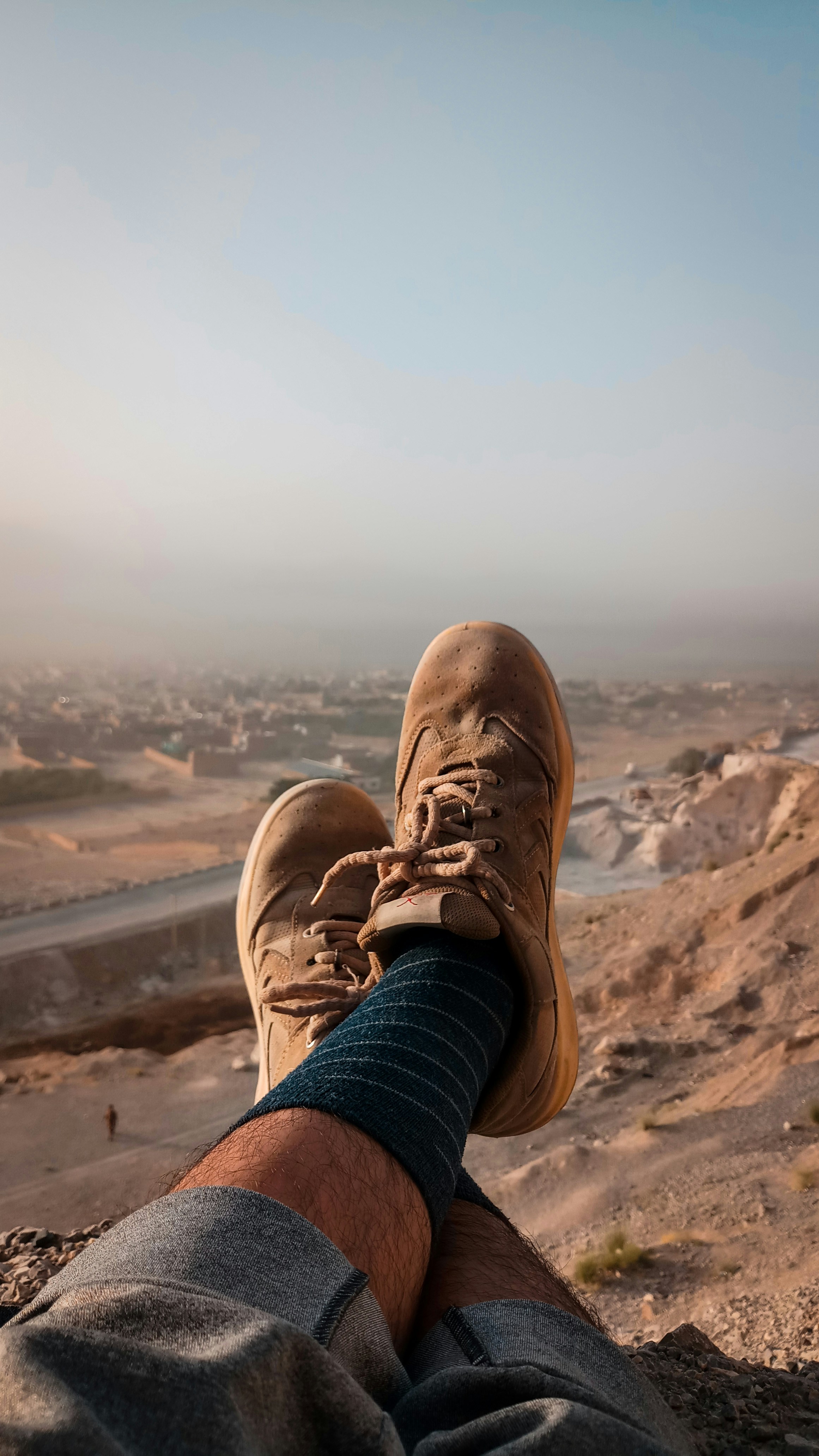 Booted respite: sunlit desert overlook with crossed legs