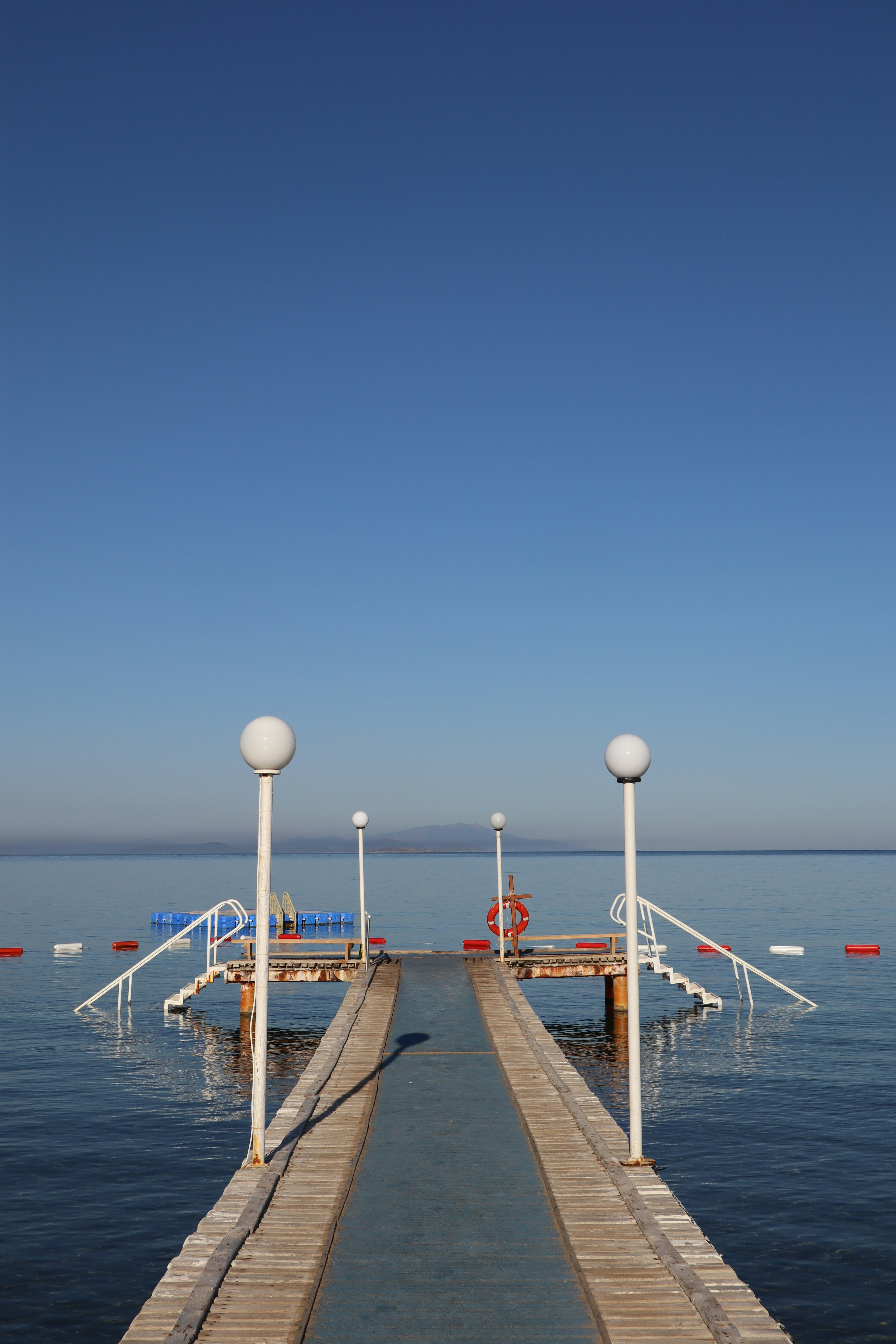 Symmetry at Sea: A Lonely Pier Extends toward the Quiet Horizon