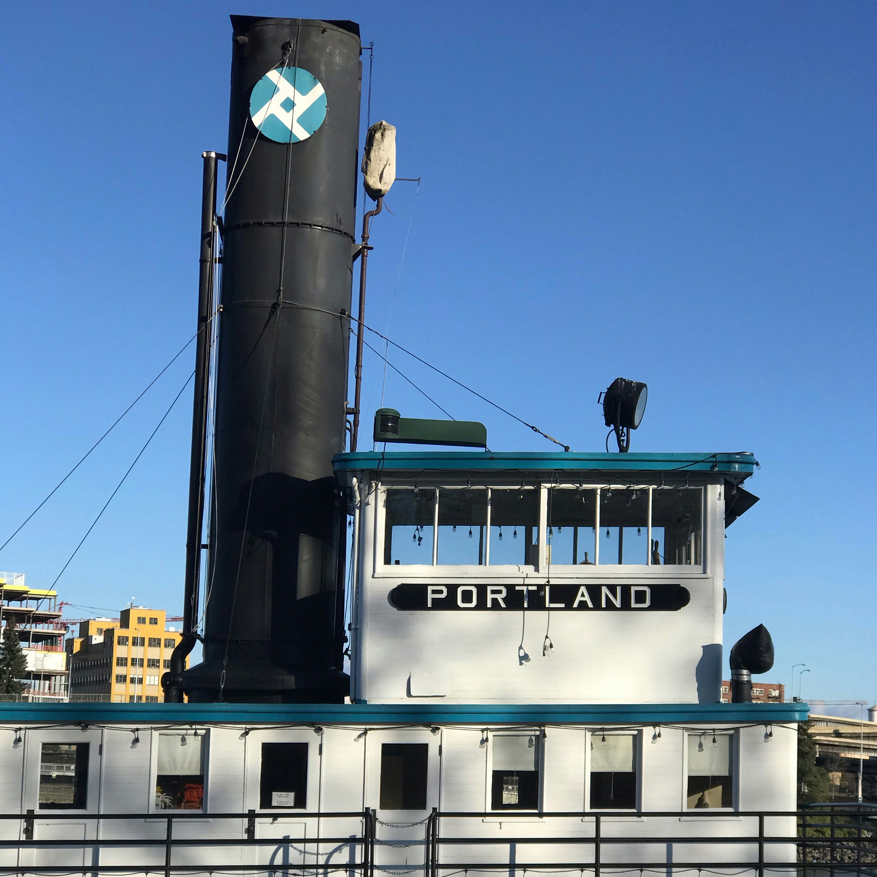Portland's Harbor Tower: A Vintage Steamship under a Clear Blue Cityscape