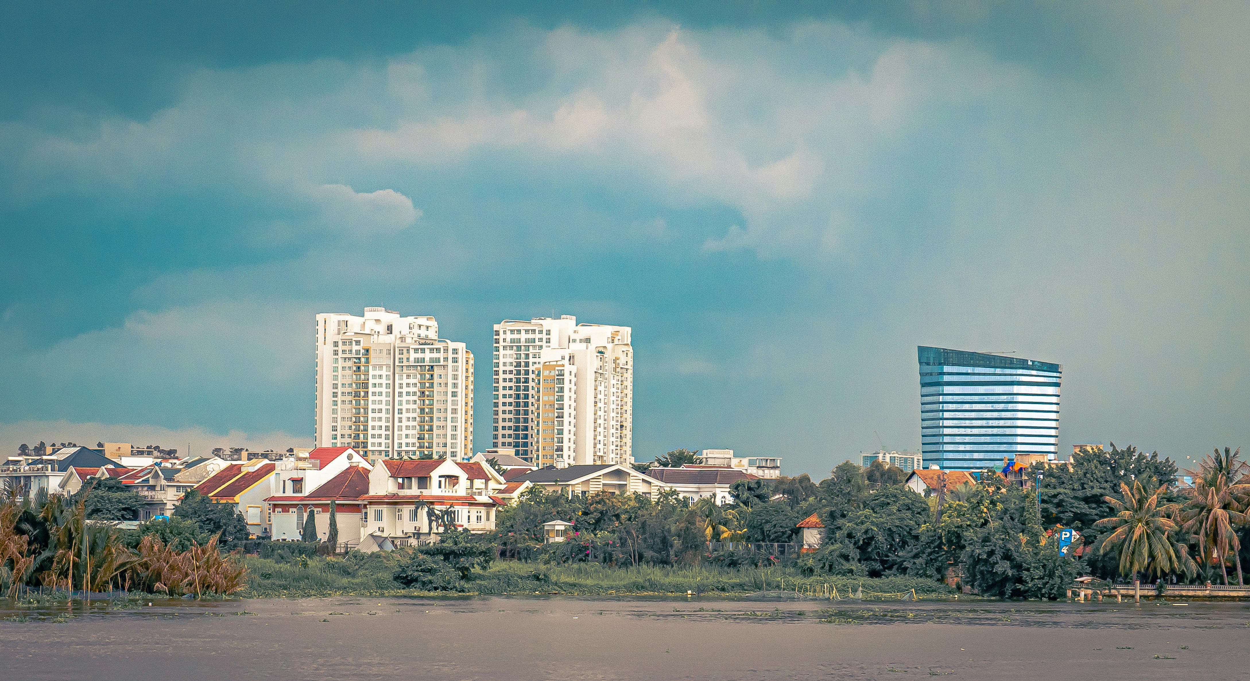City buildings near green trees under blue sky during daytime photo ...