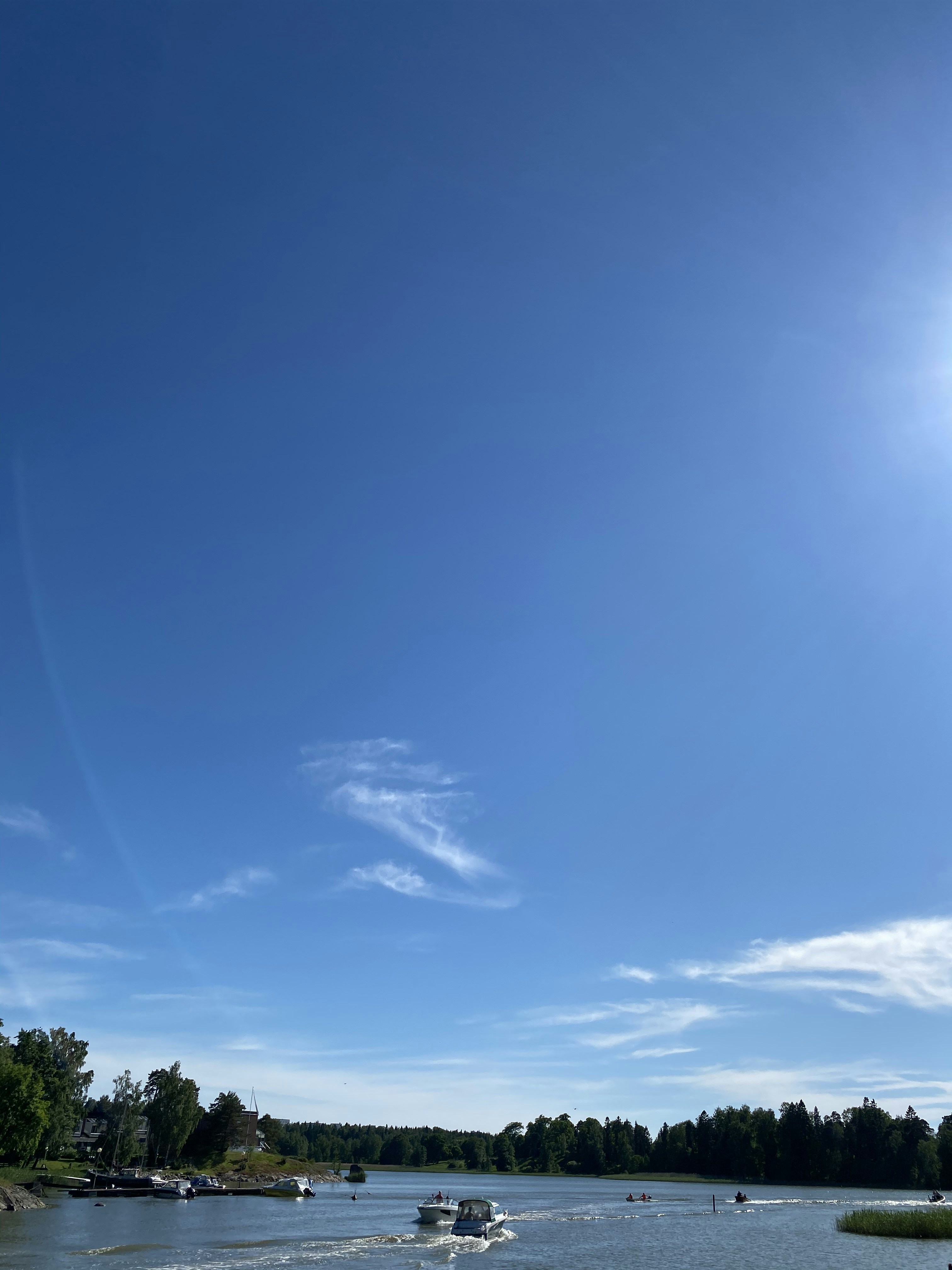 Cobalt Sky Over a Quiet Riverside with Boats on Calm Waters