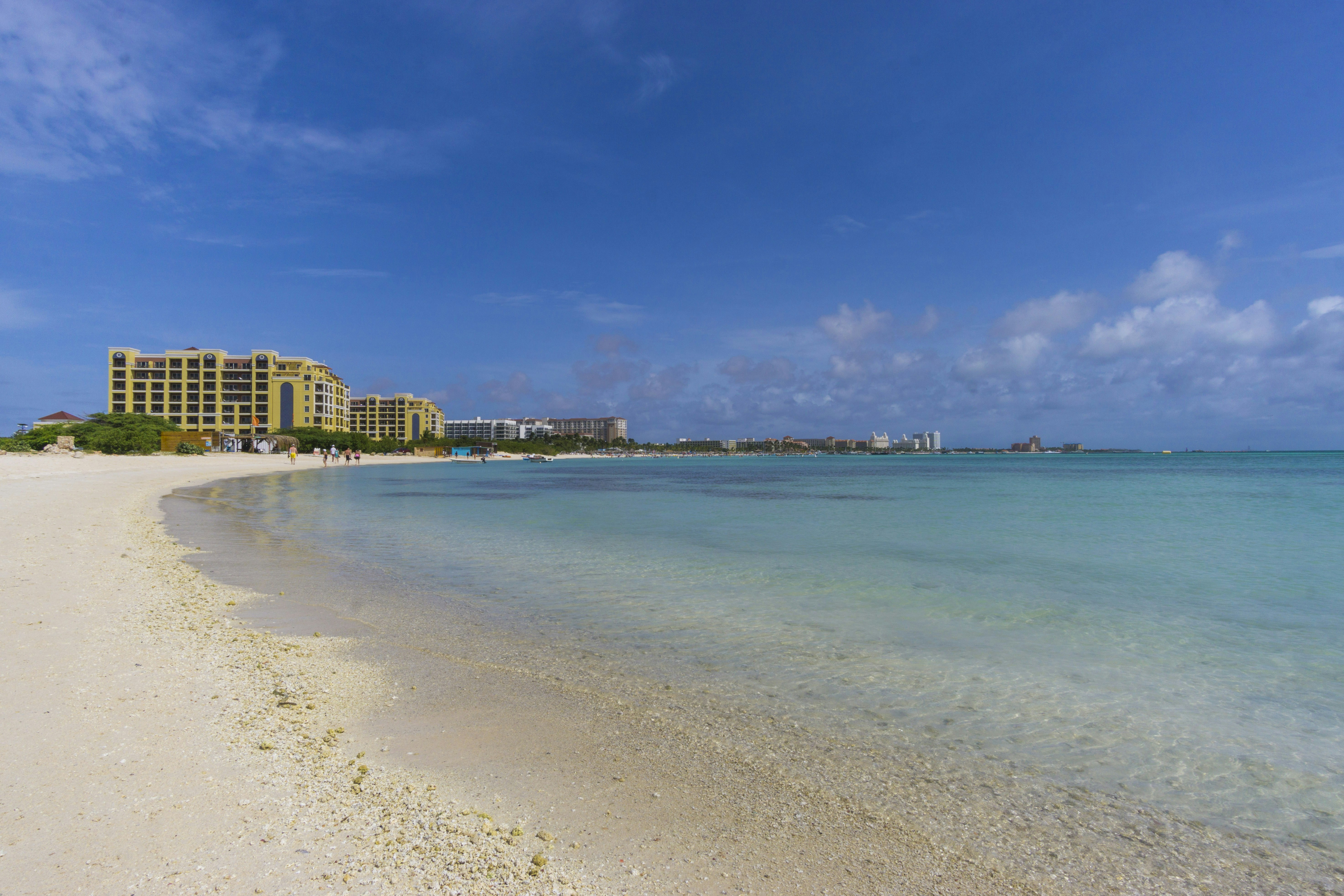 White and brown concrete building near sea under blue sky during ...