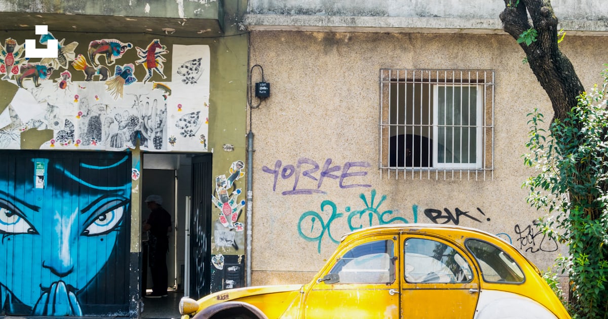 Yellow Volkswagen Beetle Parked Beside White Concrete Building During