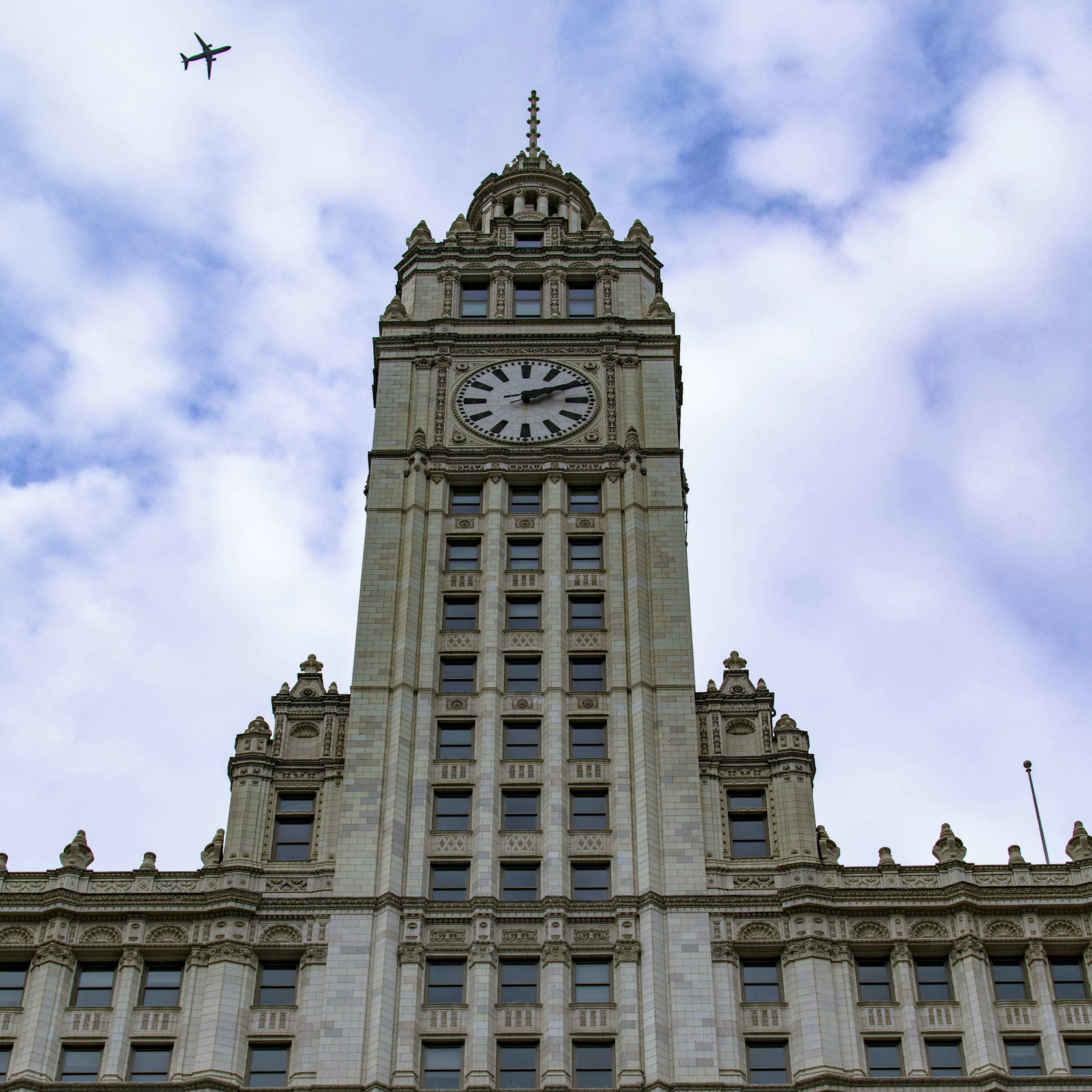 Clock Tower Piercing the Sky Over a Symmetrical City Facade