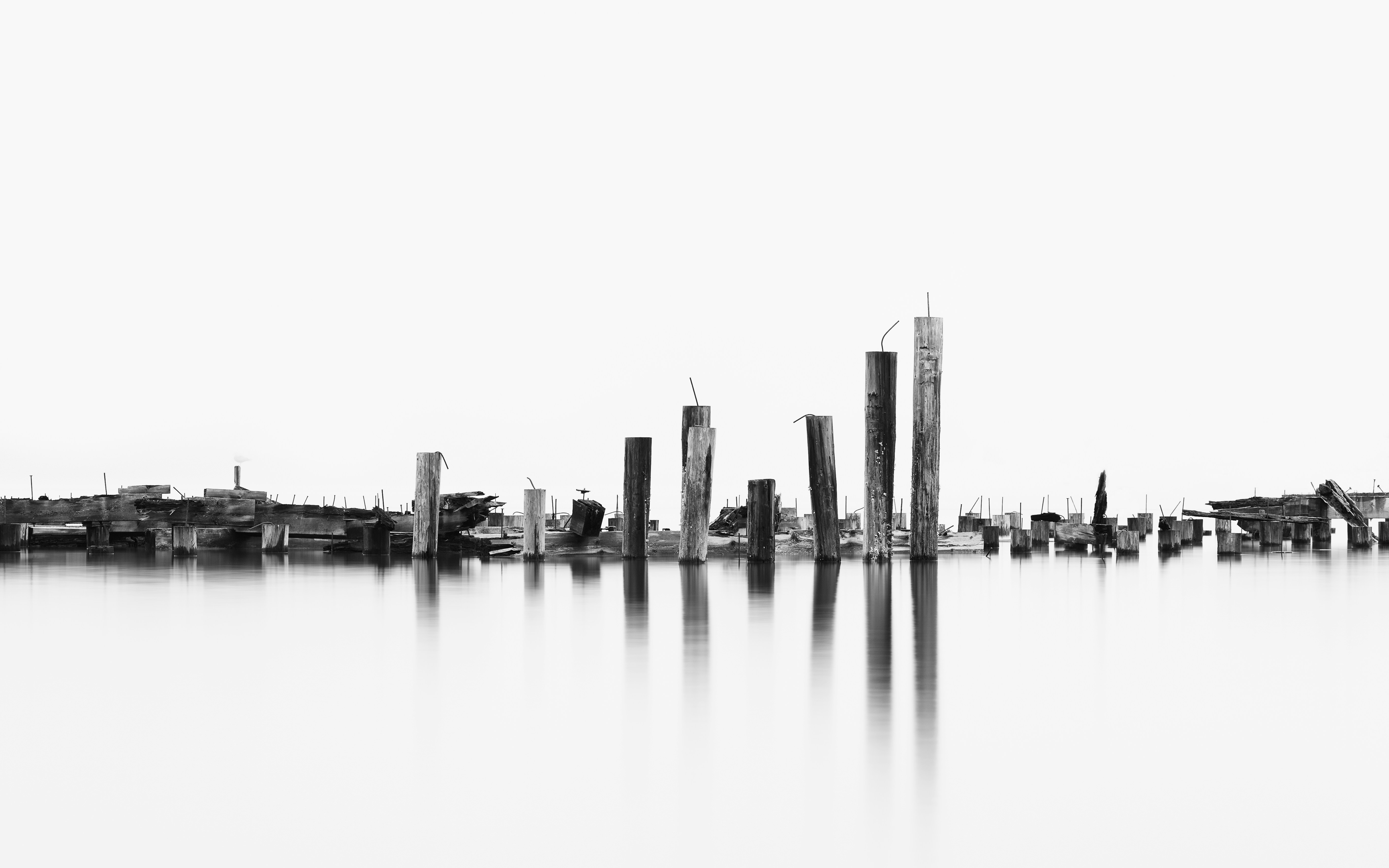 Grayscale city skyline reflected on a calm water surface.
