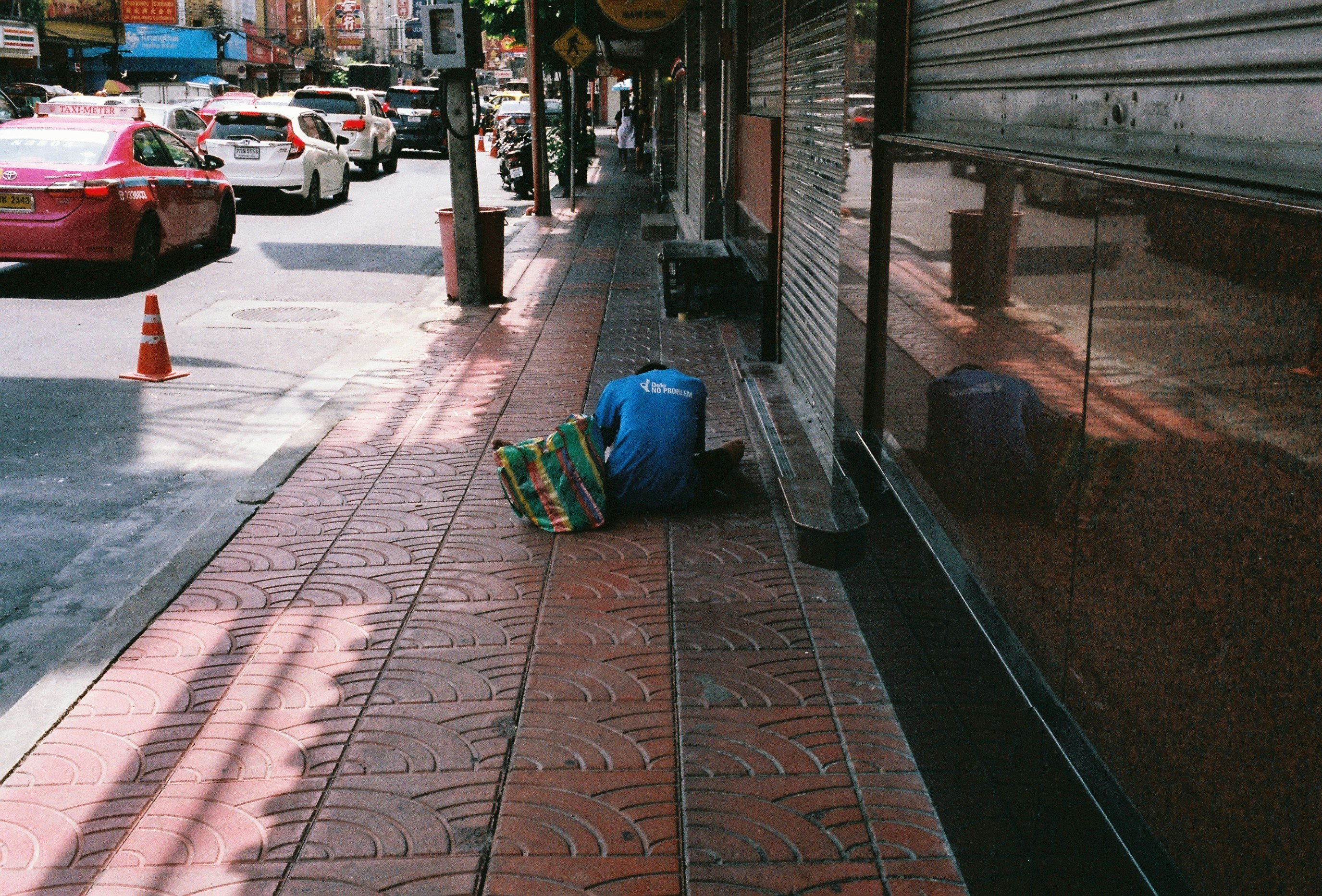 Blue-clad Figure on a Sunlit Urban Walkway