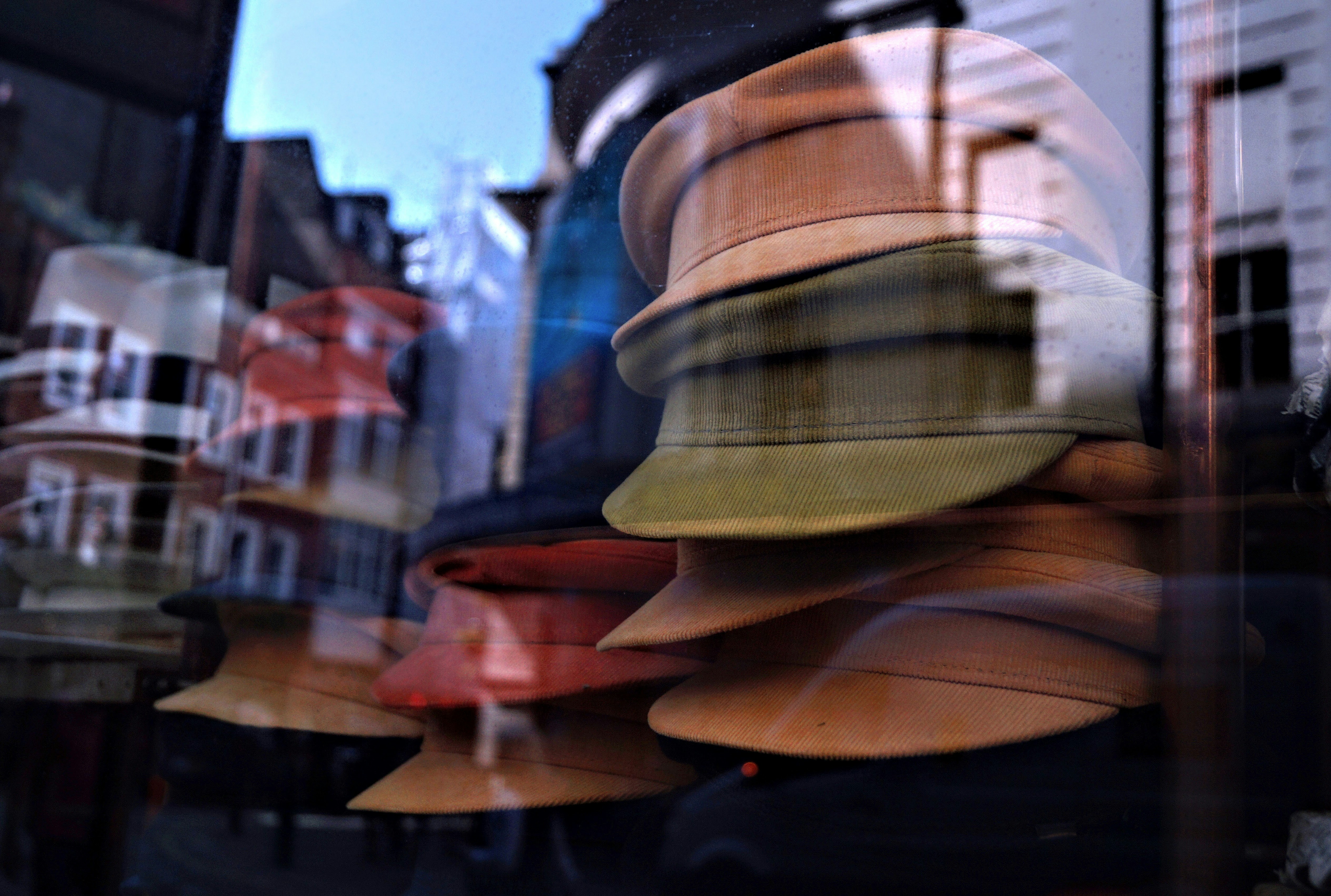 Reflections in Glass: Stacked Bowler Hats Form an Abstract Window Portrait