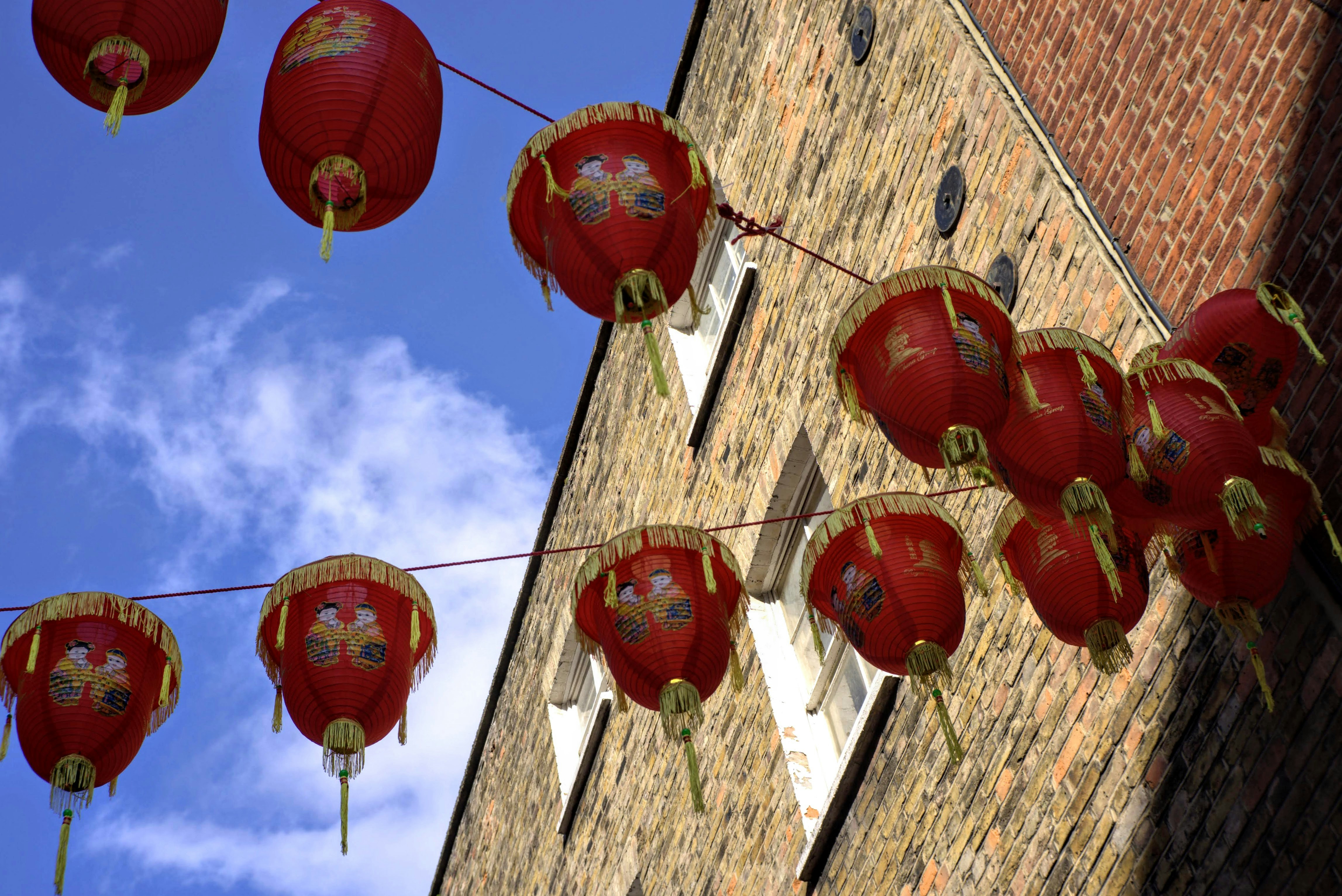 Lantern Strings Against a Brick Sky