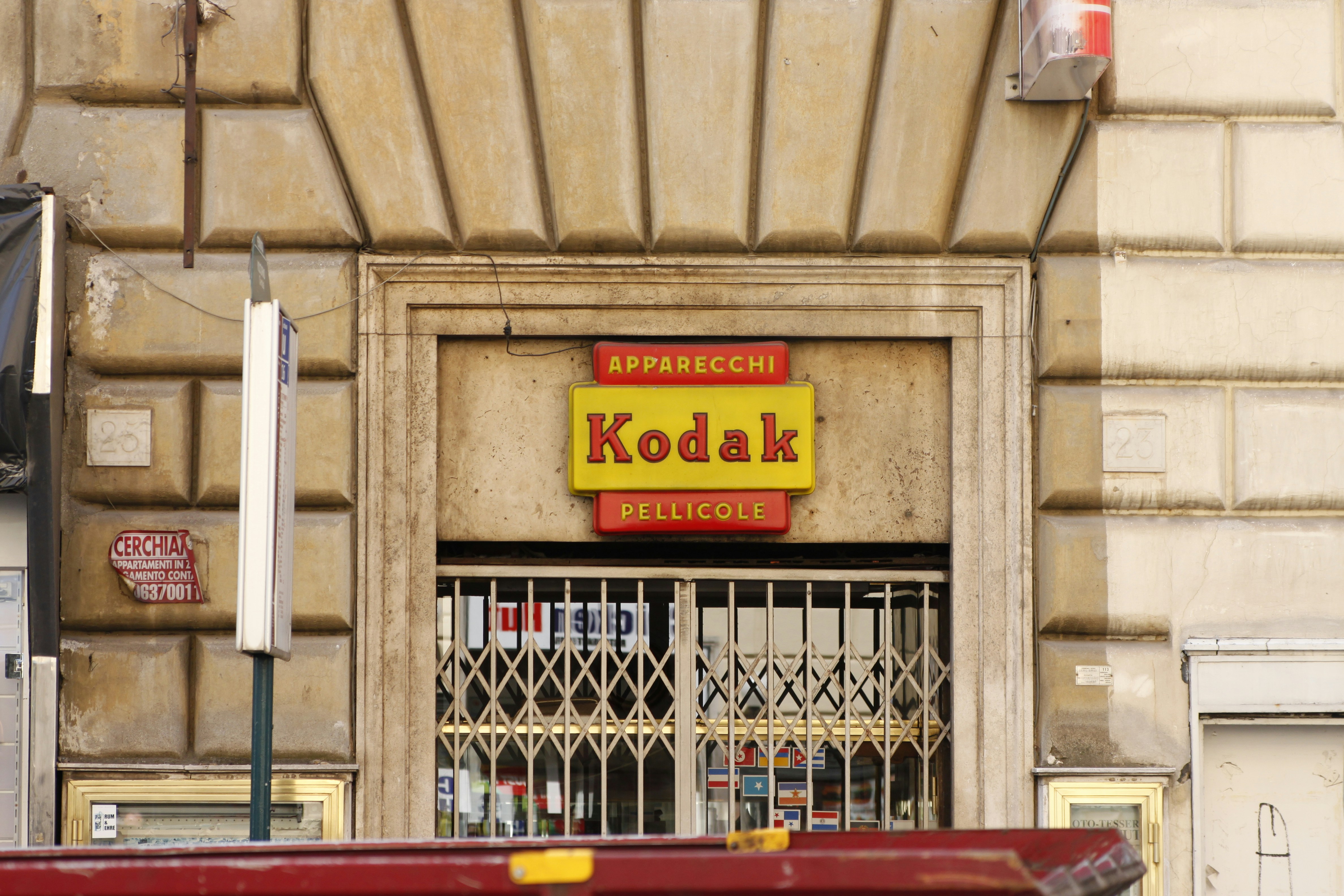 Kodak Glow: A Central Sign Framed by Iron Grilles on a Historic Facade