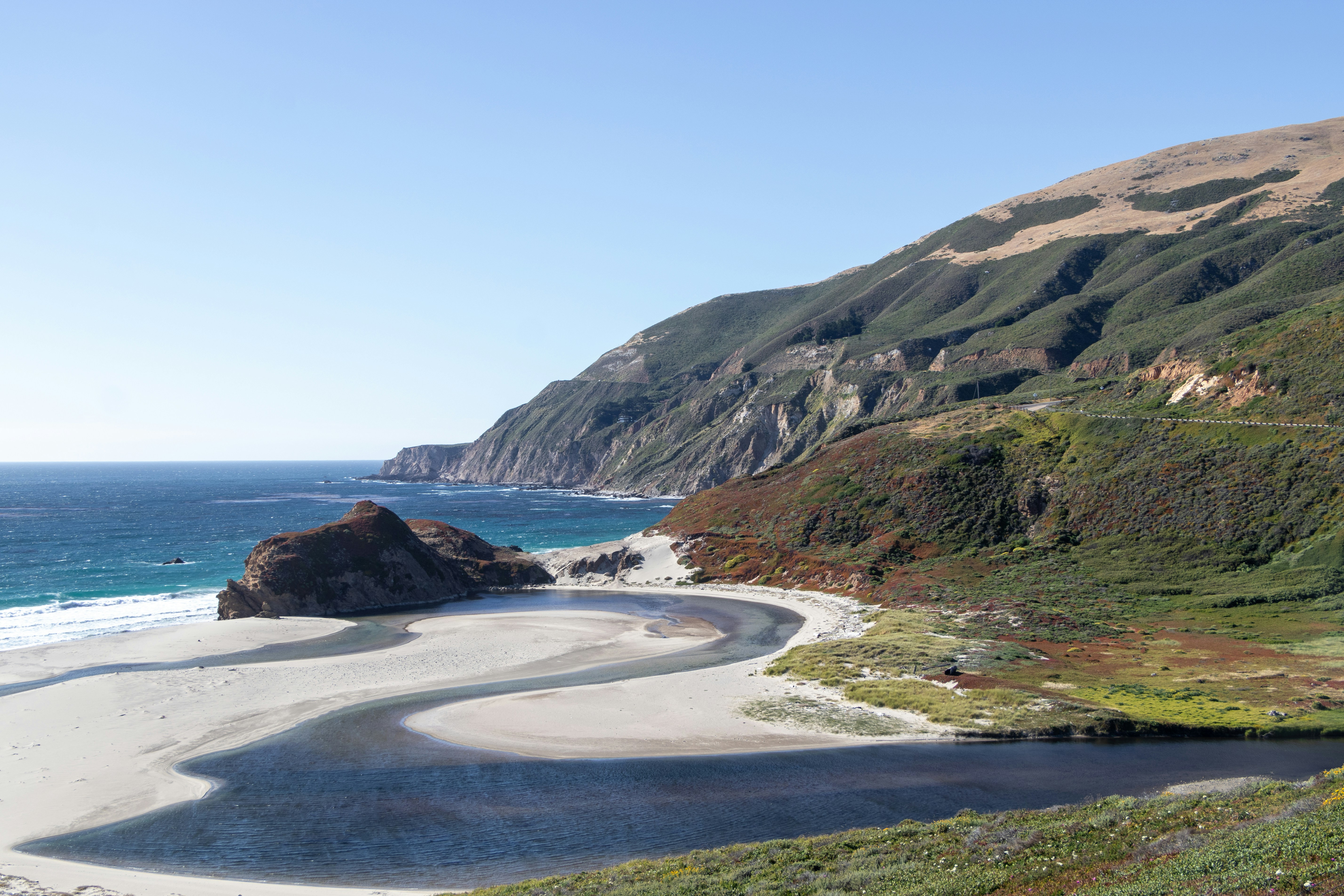 Green and brown mountain beside body of water during daytime photo ...