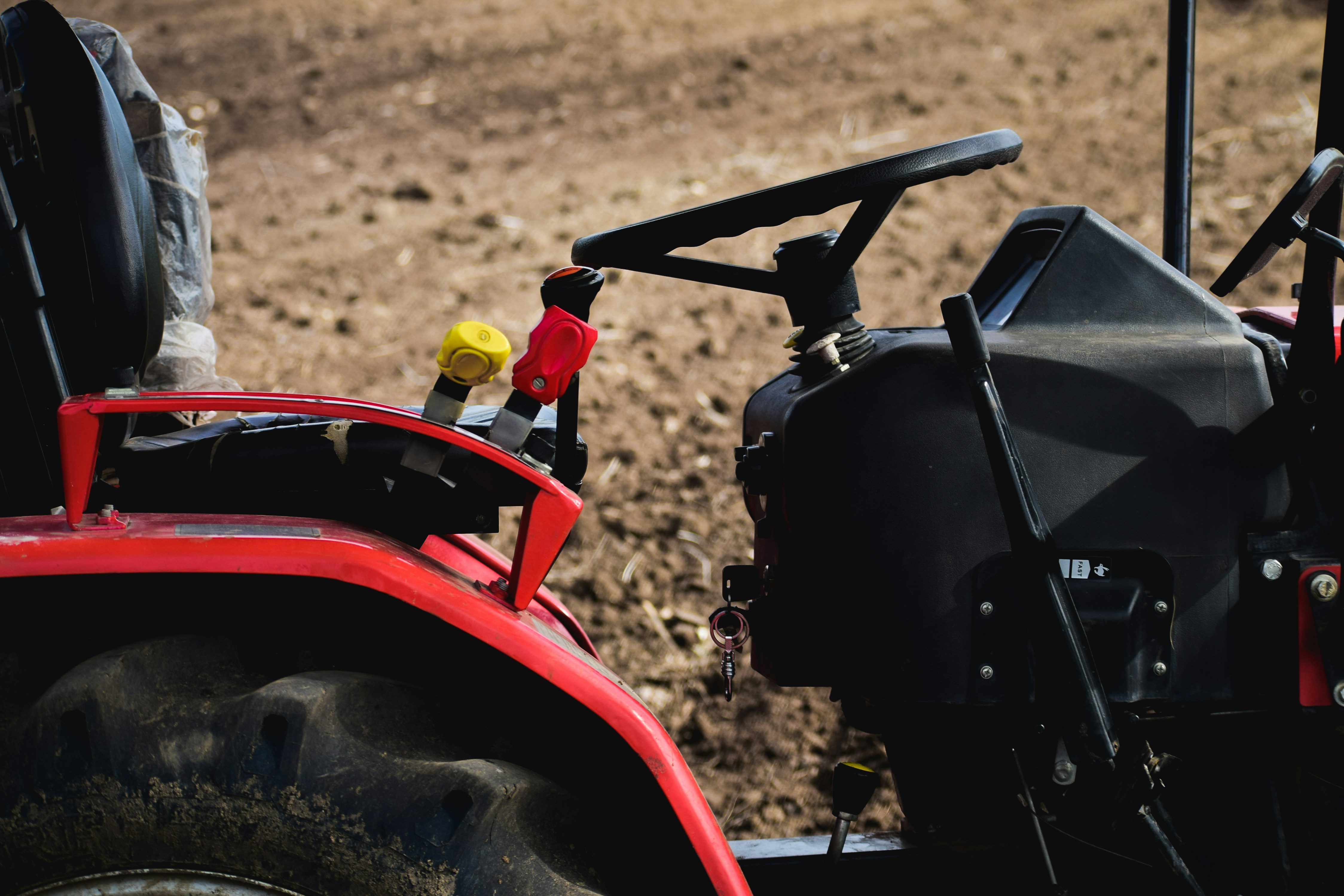 Close-up of a tractor's control panel, showcasing the intricate details of the steering wheel and hydraulic levers. 
