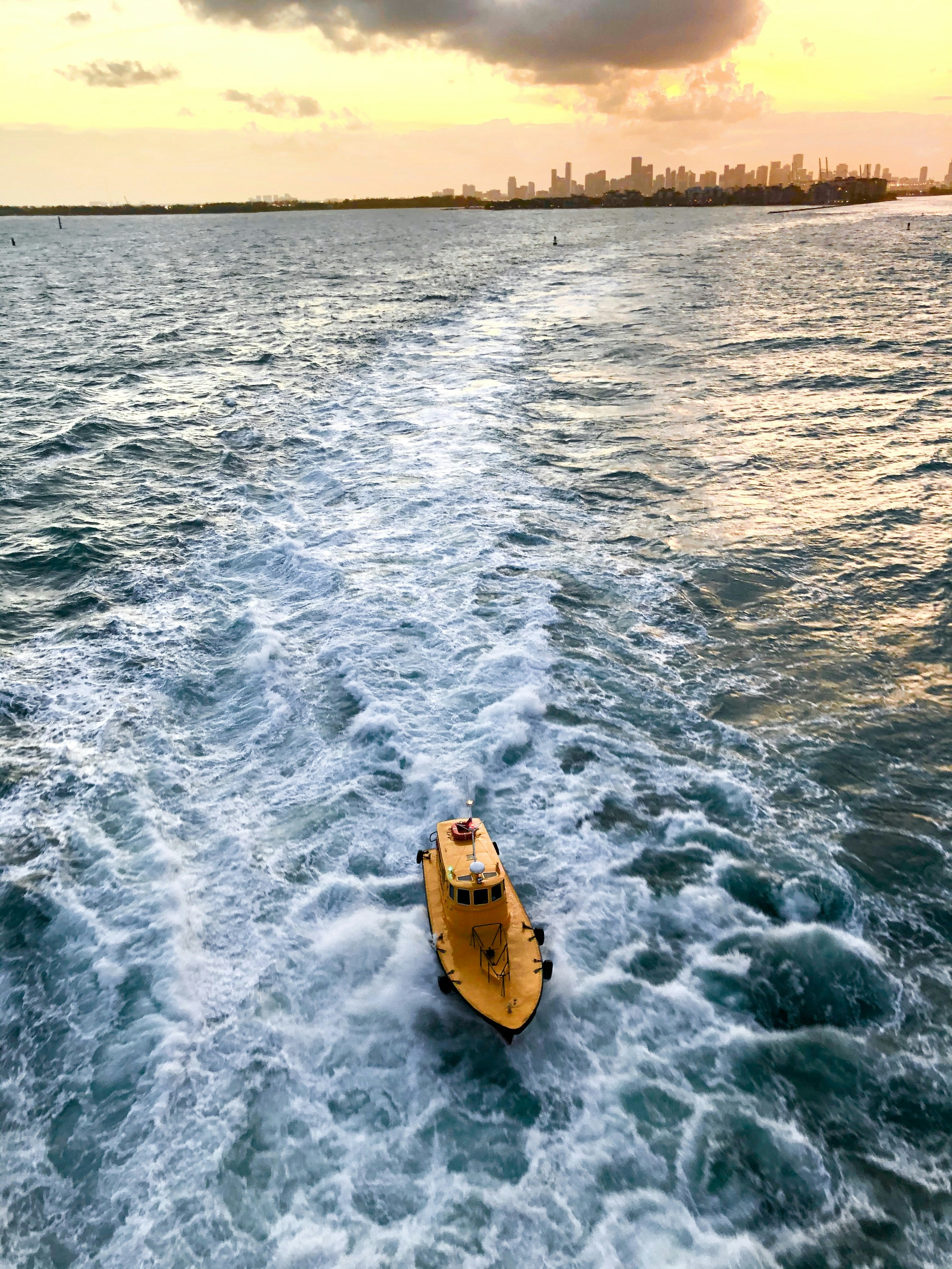 Golden Wake: Tugboat Carves Toward the Sunset City Horizon