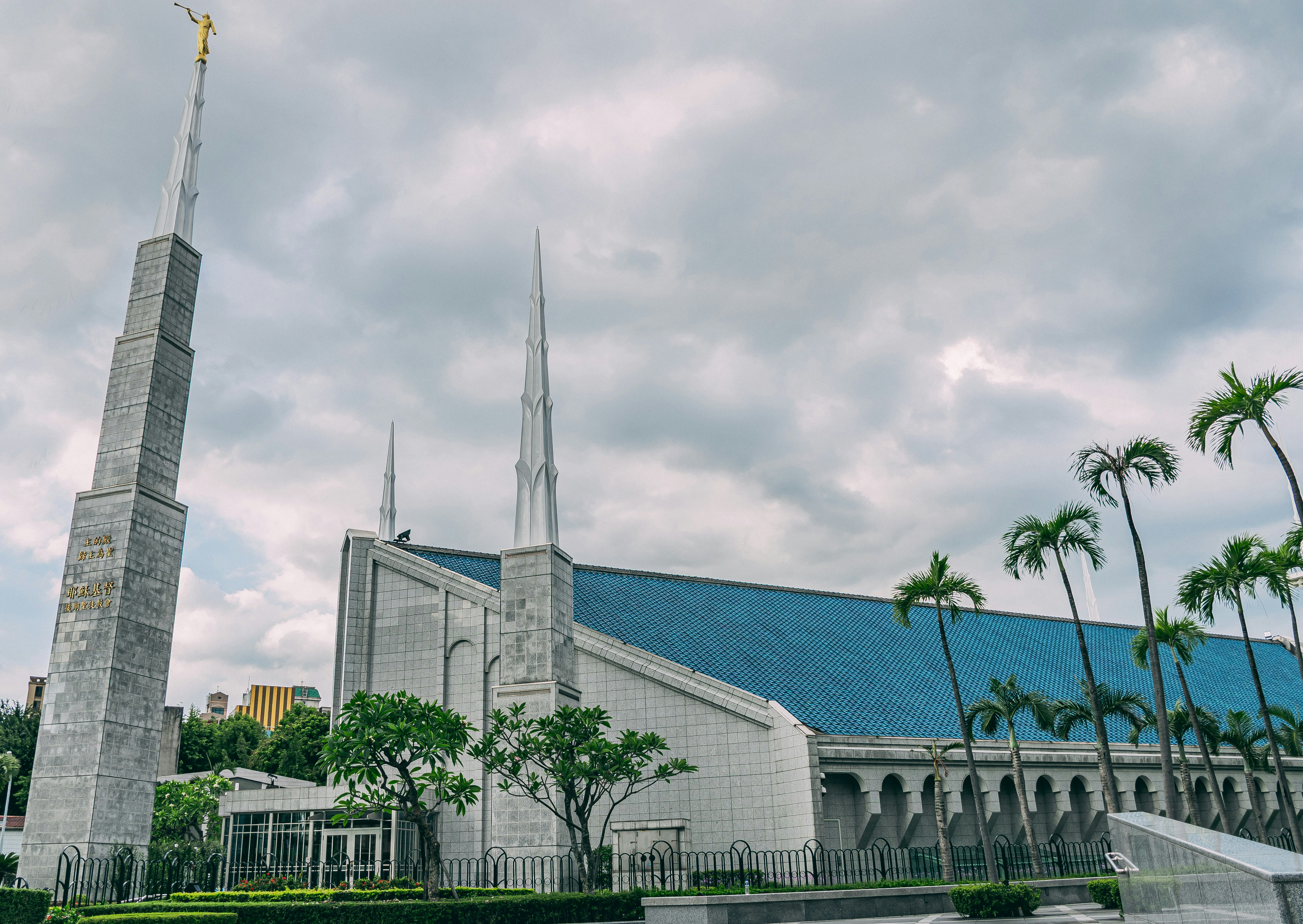 Spire-Topped Chapel Under a Moody Sky with Palm Fronds