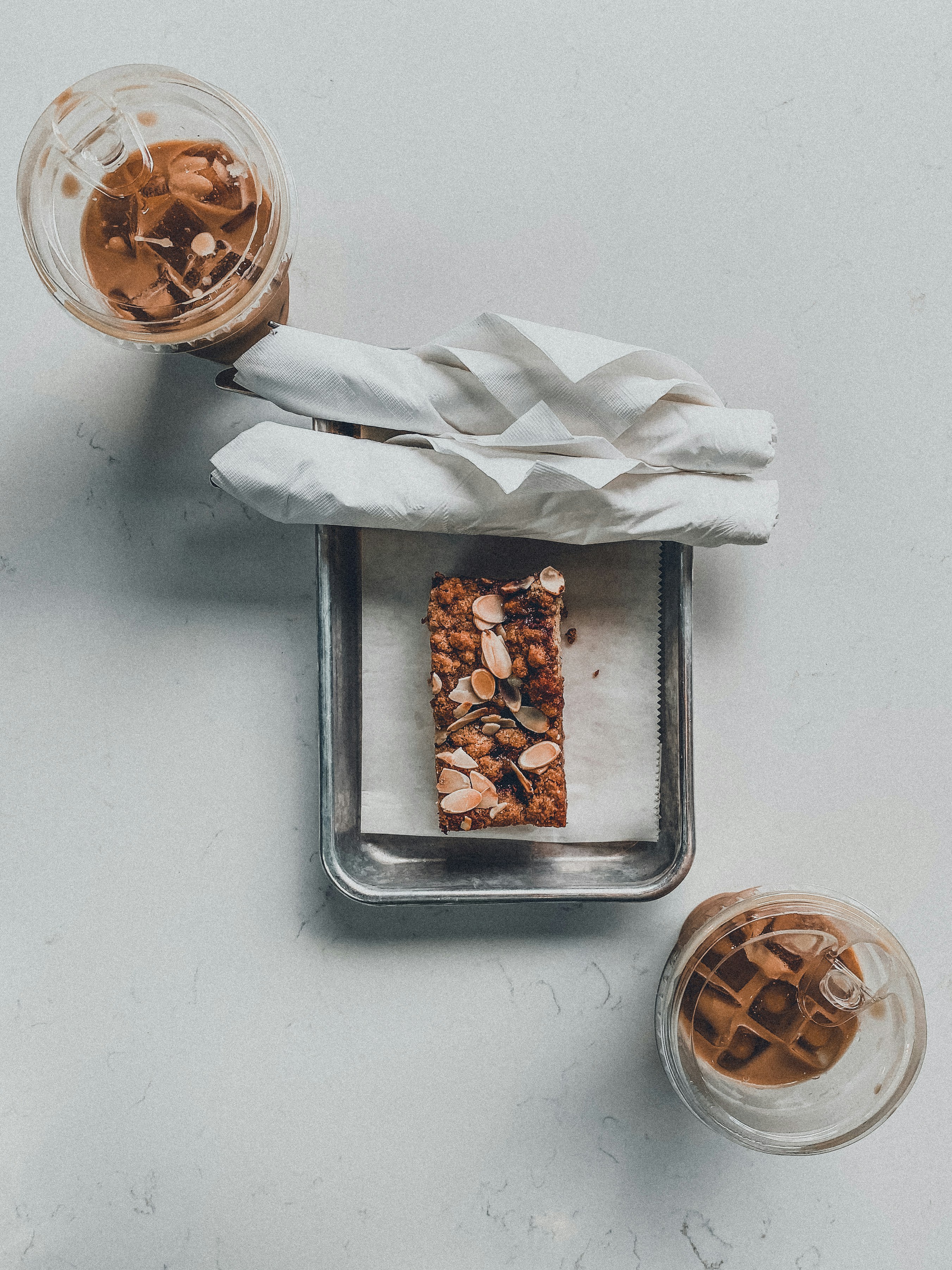 Almond-Crowned Bar in a Mini Bake Pan, Flanked by Iced Coffees
