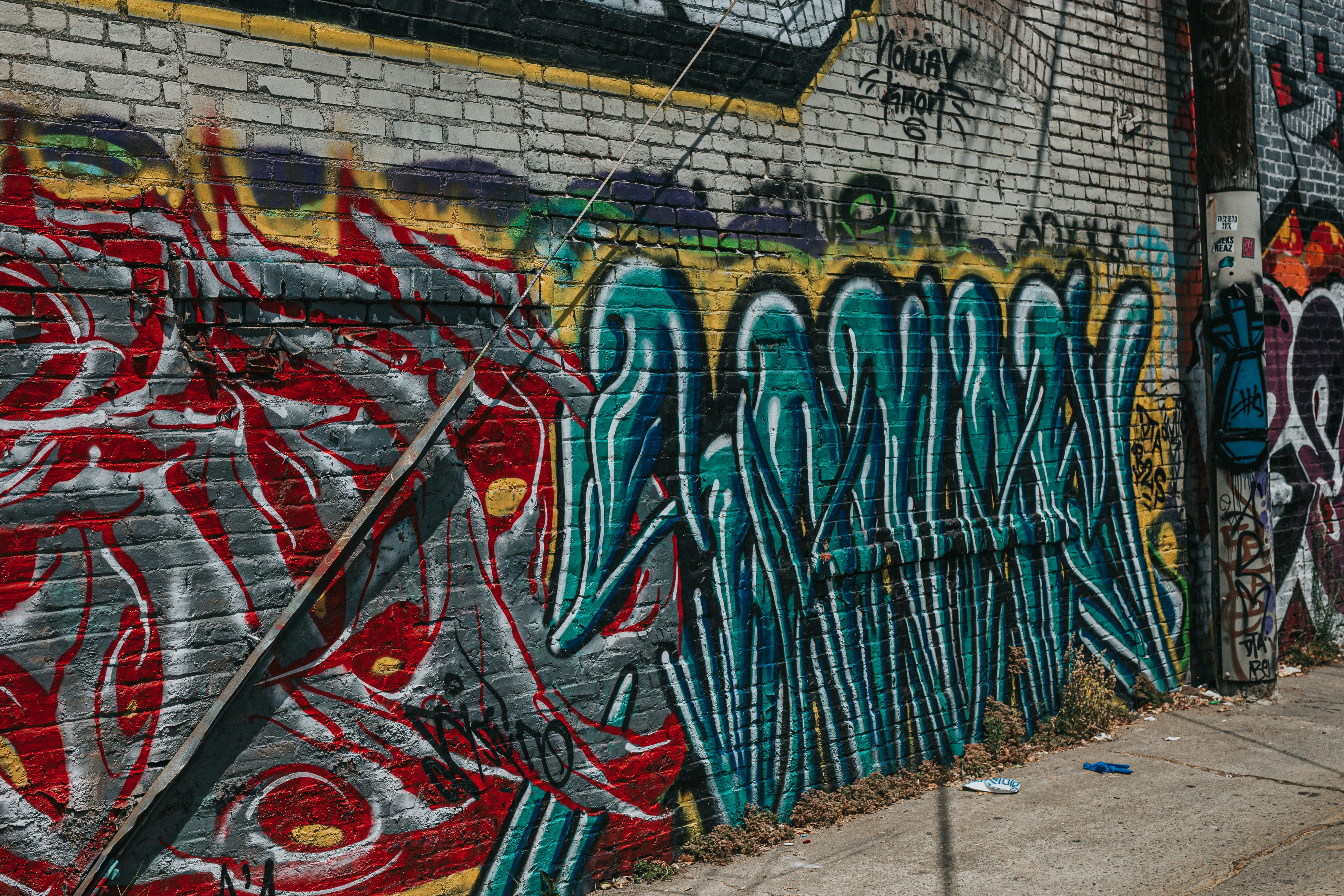 Vibrant graffiti mural showcasing intricate designs and bold colors on a brick wall. The artwork reflects urban culture and artistic expression.