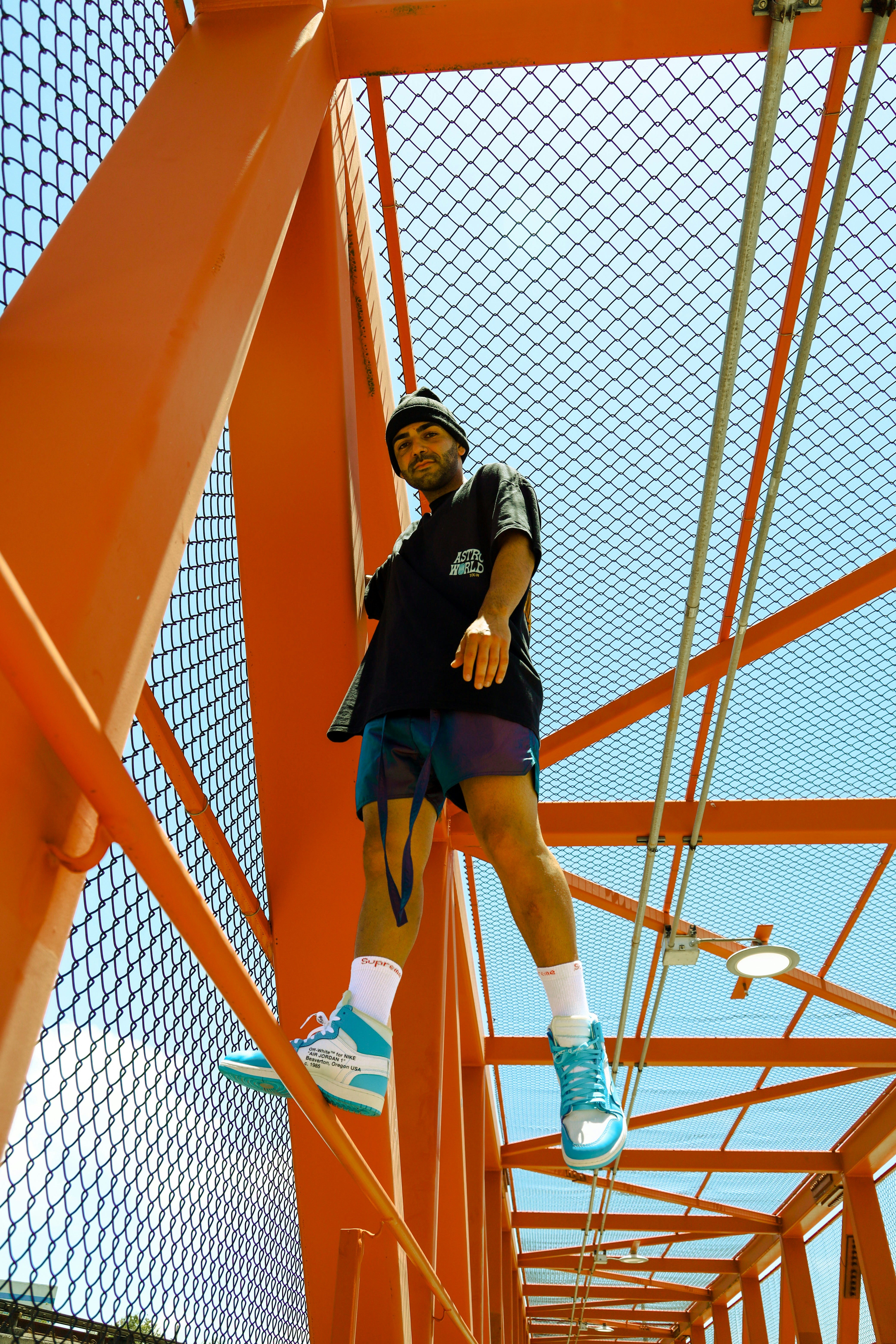 Orange Skyway Stance: A Low-Angle Portrait Above the Mesh