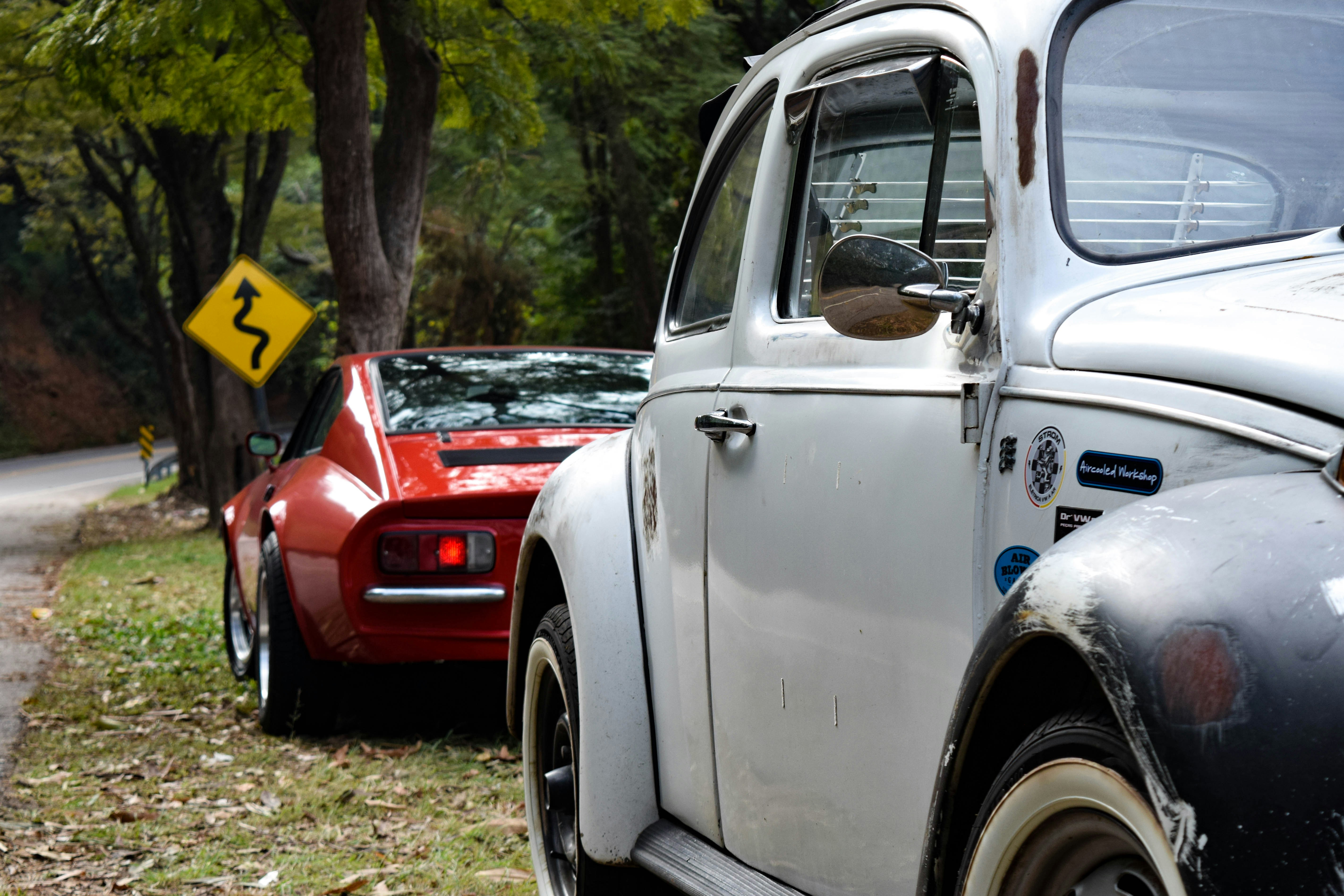 Rust and Roadside Curves: A Pair of Vintage Cars on a Winding Lane