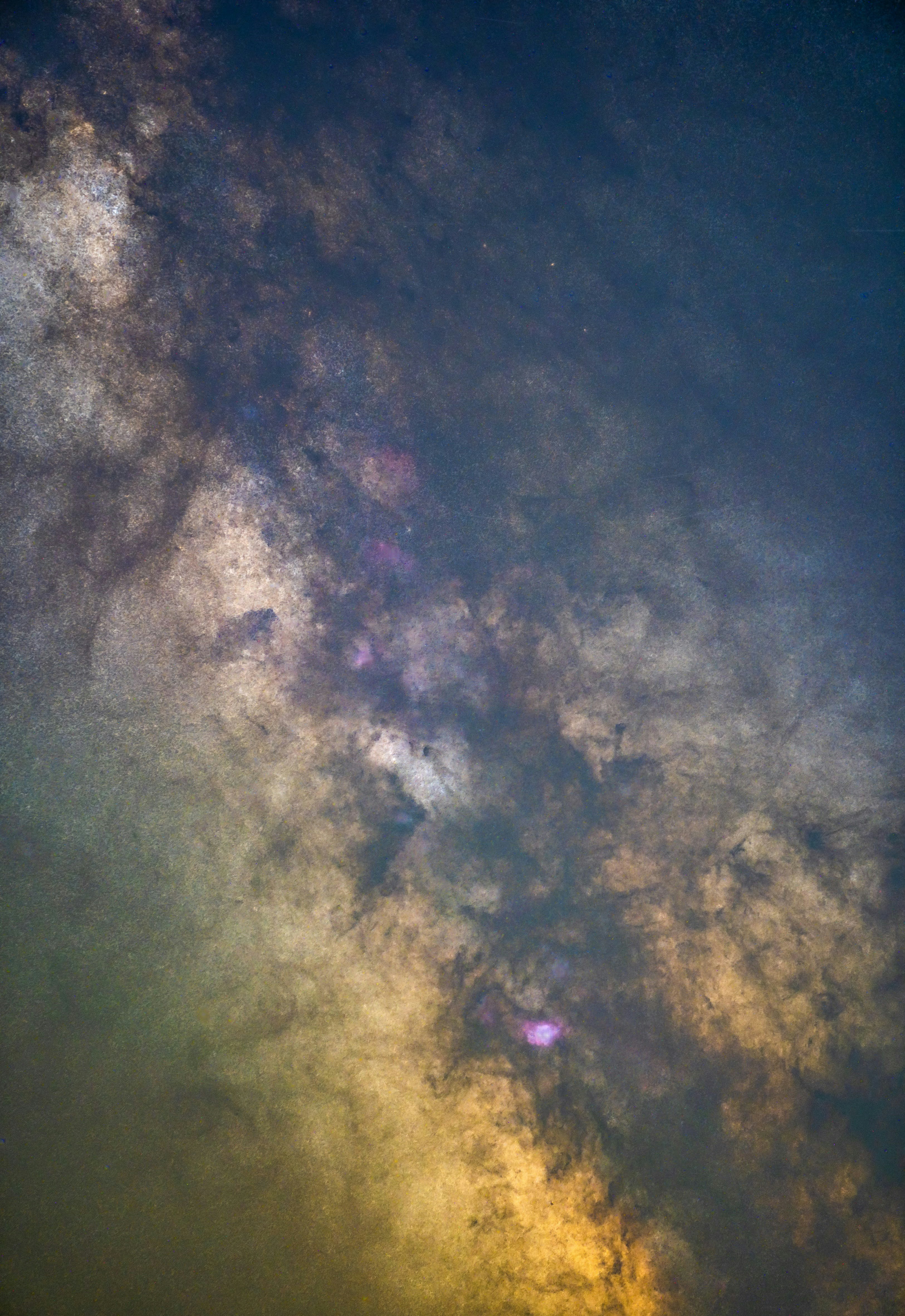 Vibrant cosmic clouds and distant stars illuminate the night sky, showcasing the beauty of the Milky Way. The ethereal colors hint at the mysteries of the universe.