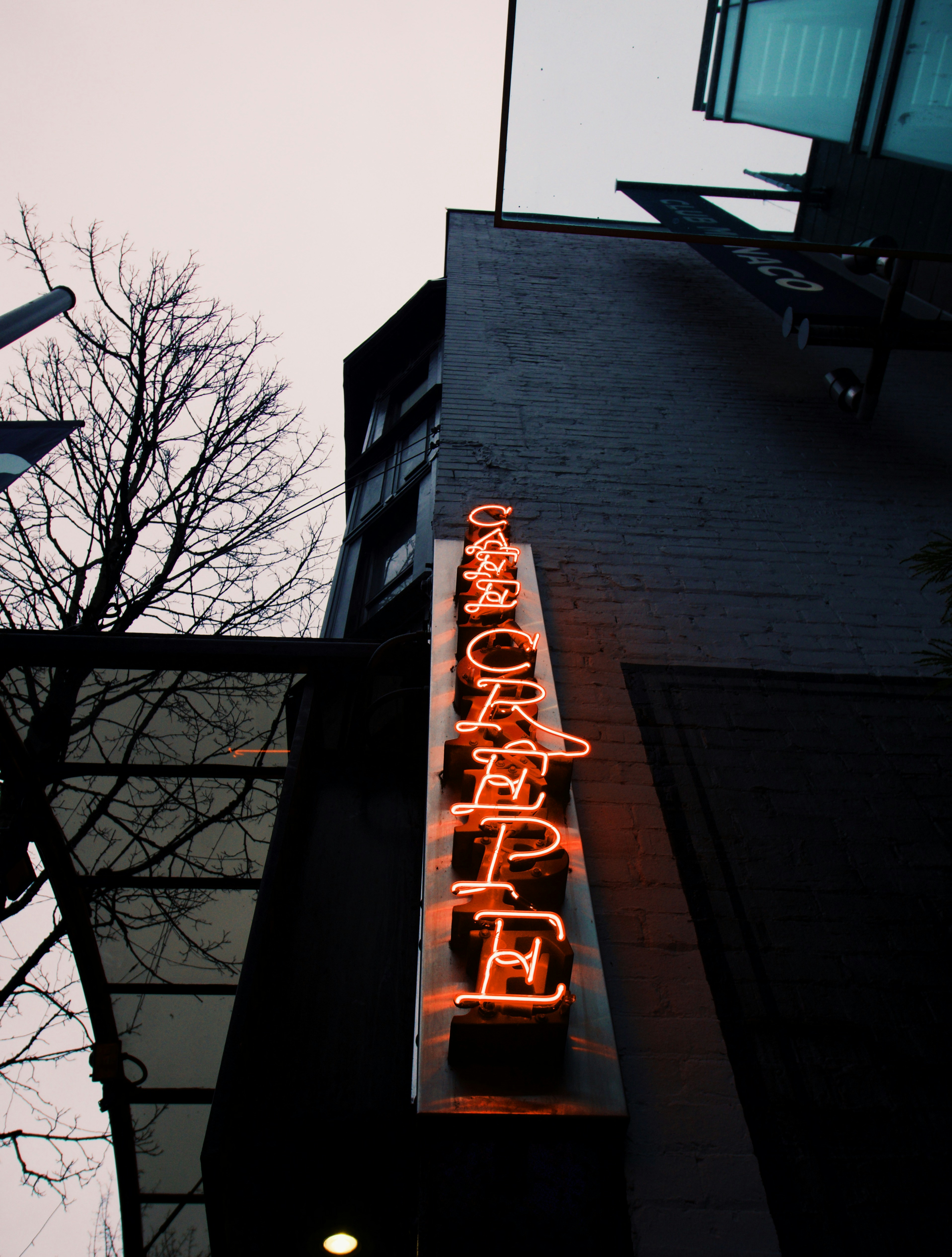 Neon Sign Vertical: A Narrow Glow on Brick Facade